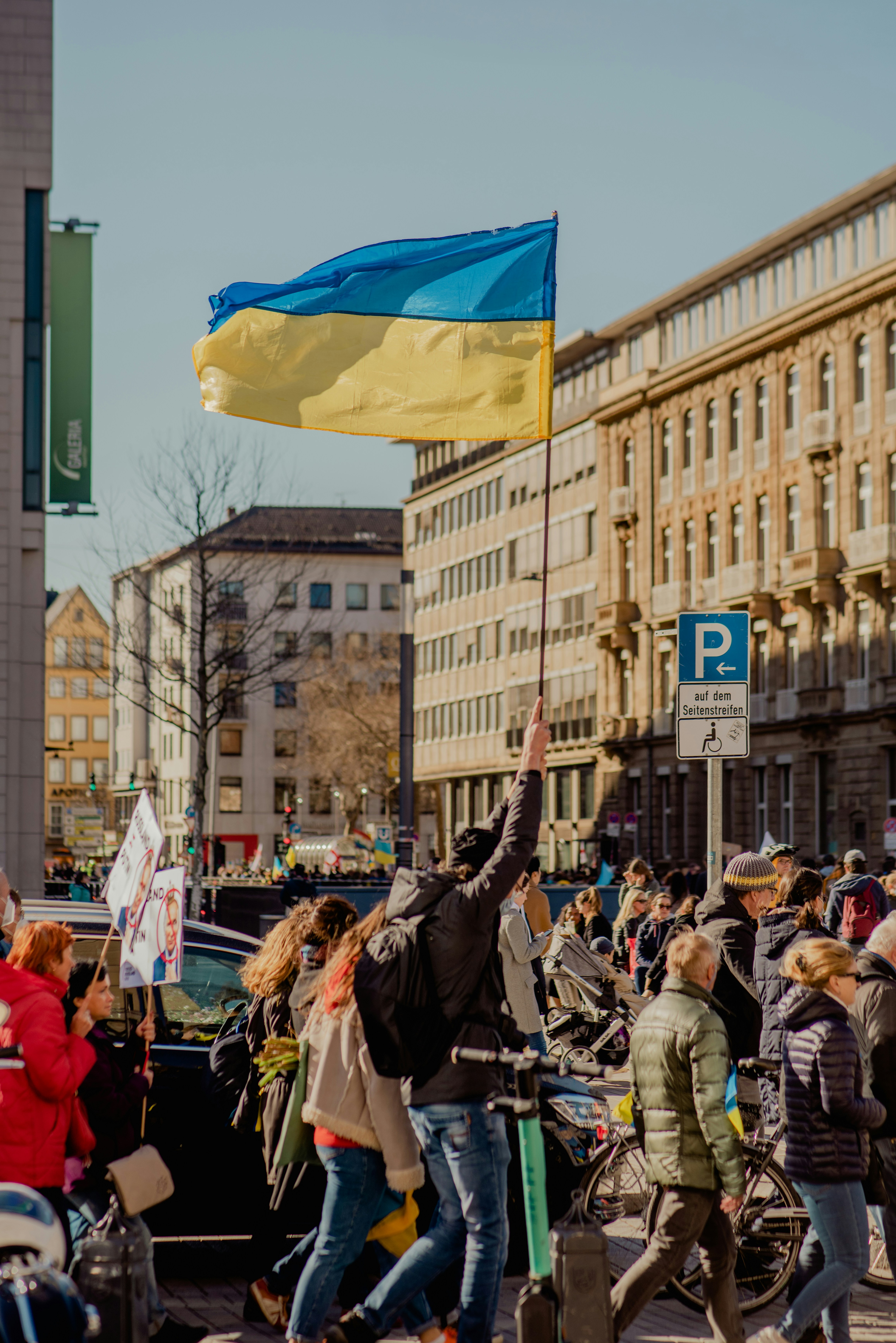 Flag Above the Crowd: A Ukrainian Solidarity Moment in Busy City Streets