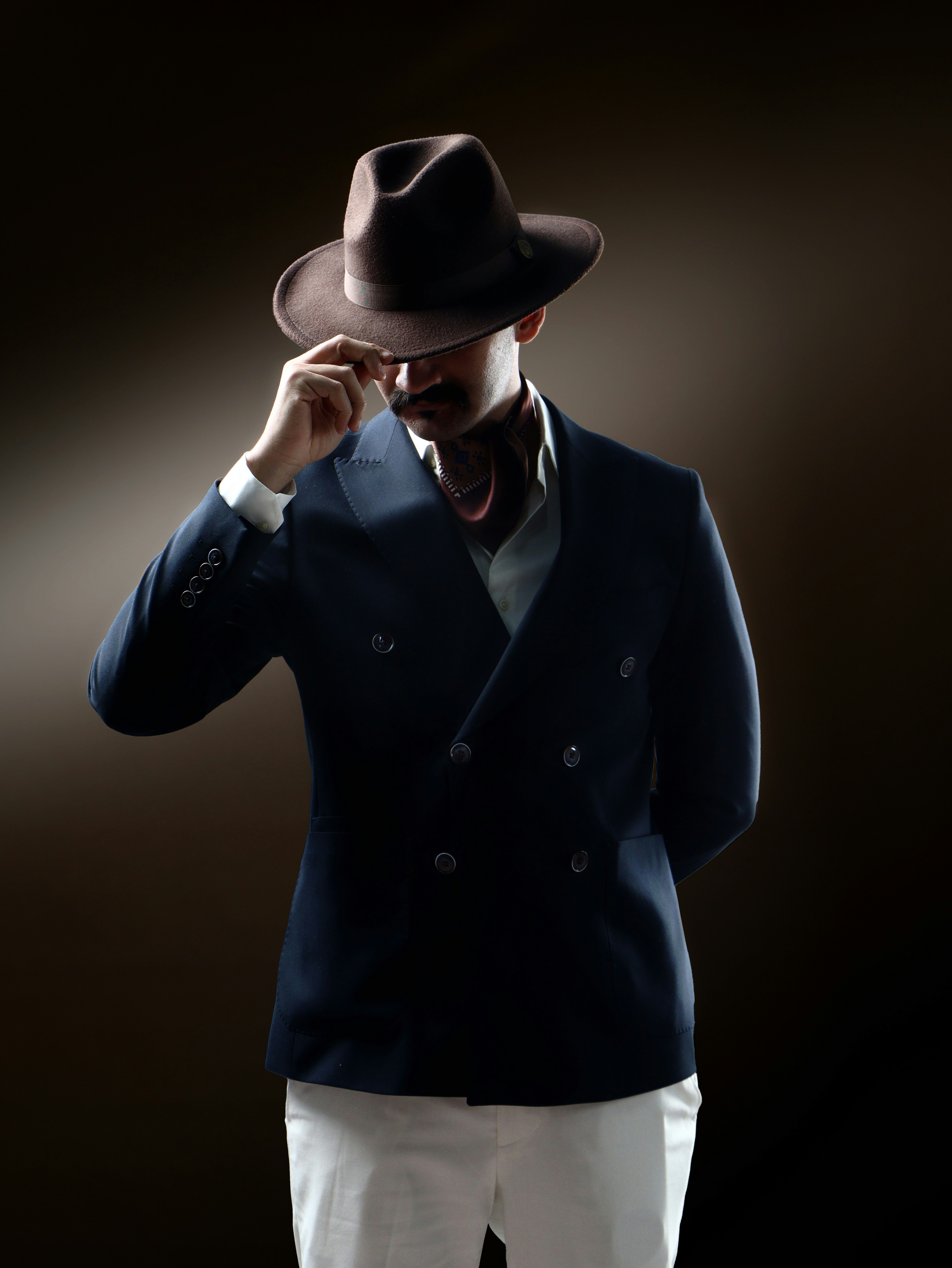 Shadowed Dapper: A Hat-Tilted Enigma in Dark Suede