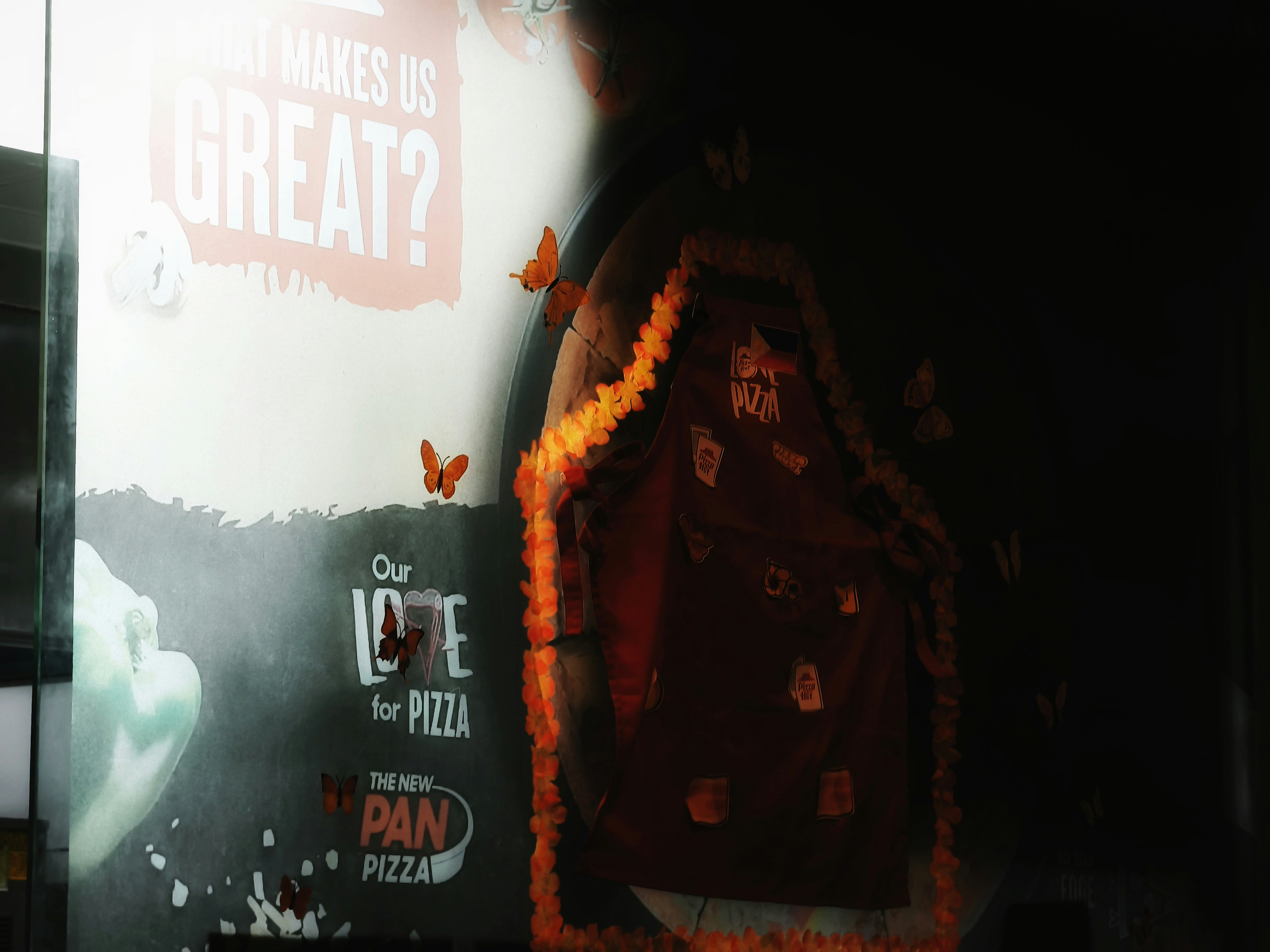 Against the Glow: A Pizza Ad Backlit by Neon and Garlands