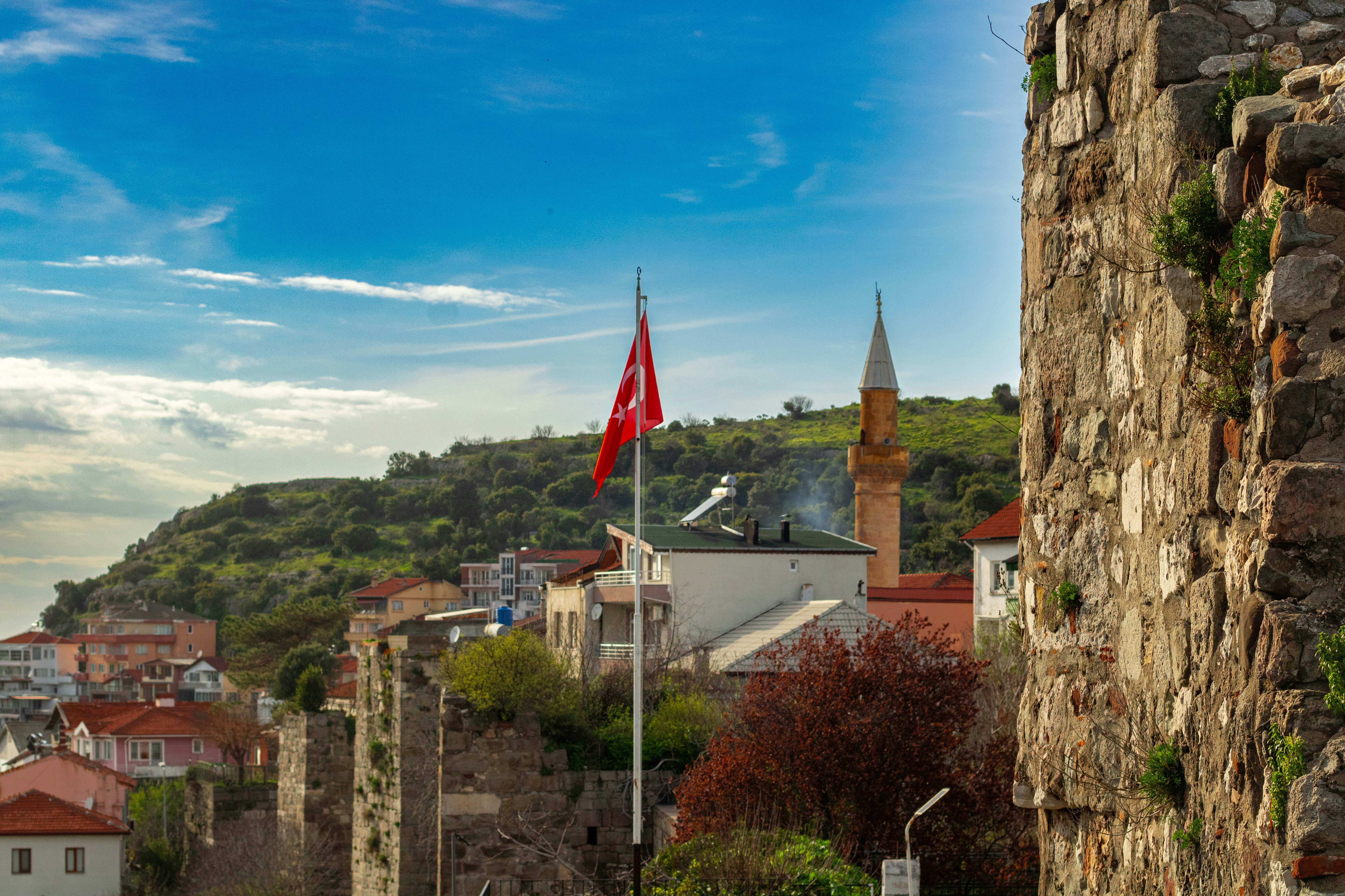 Flag over ancient walls: a sunlit Turkish town