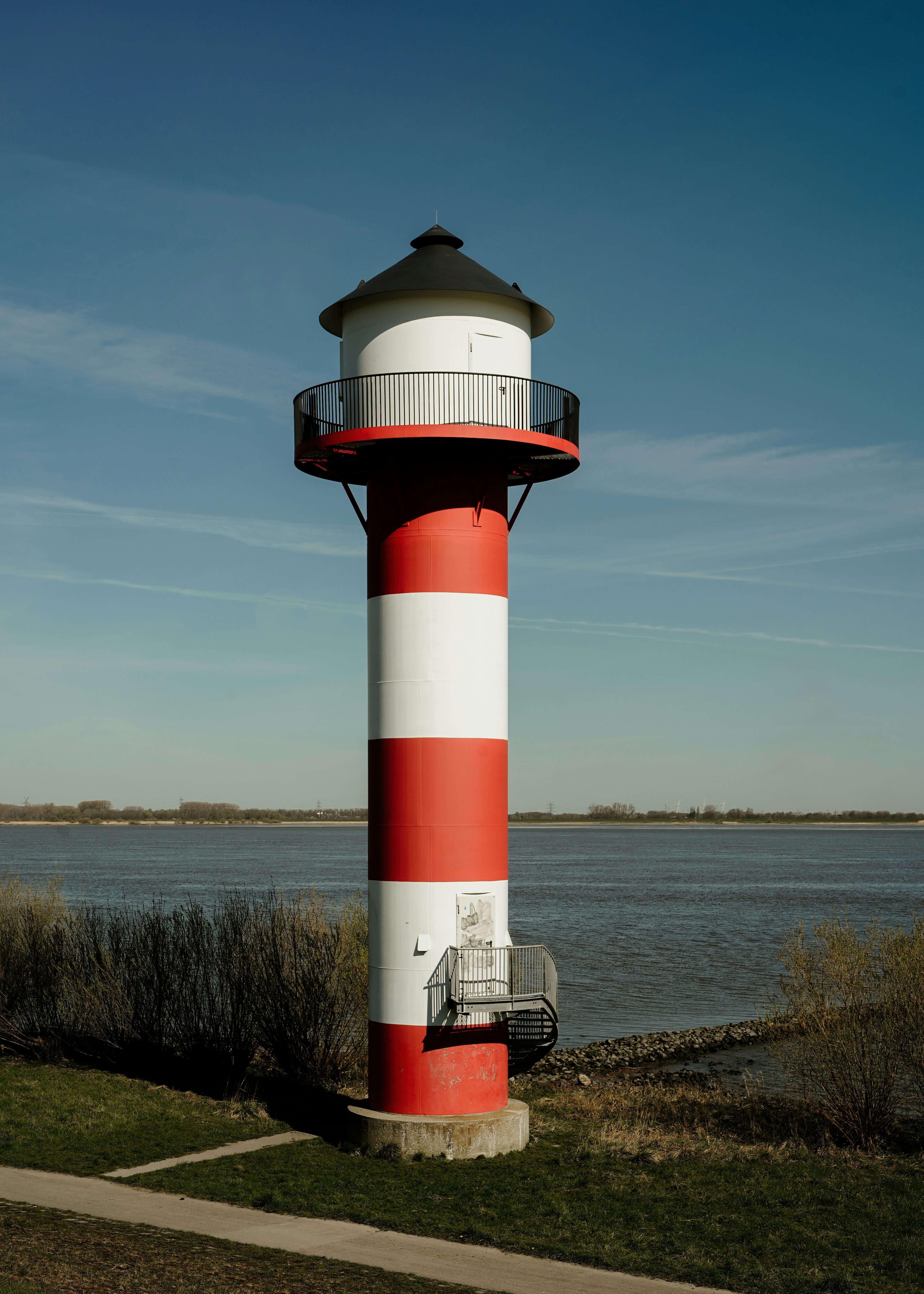 Red-White Sentinel: A Coastal Lighthouse Above the Quiet Shore
