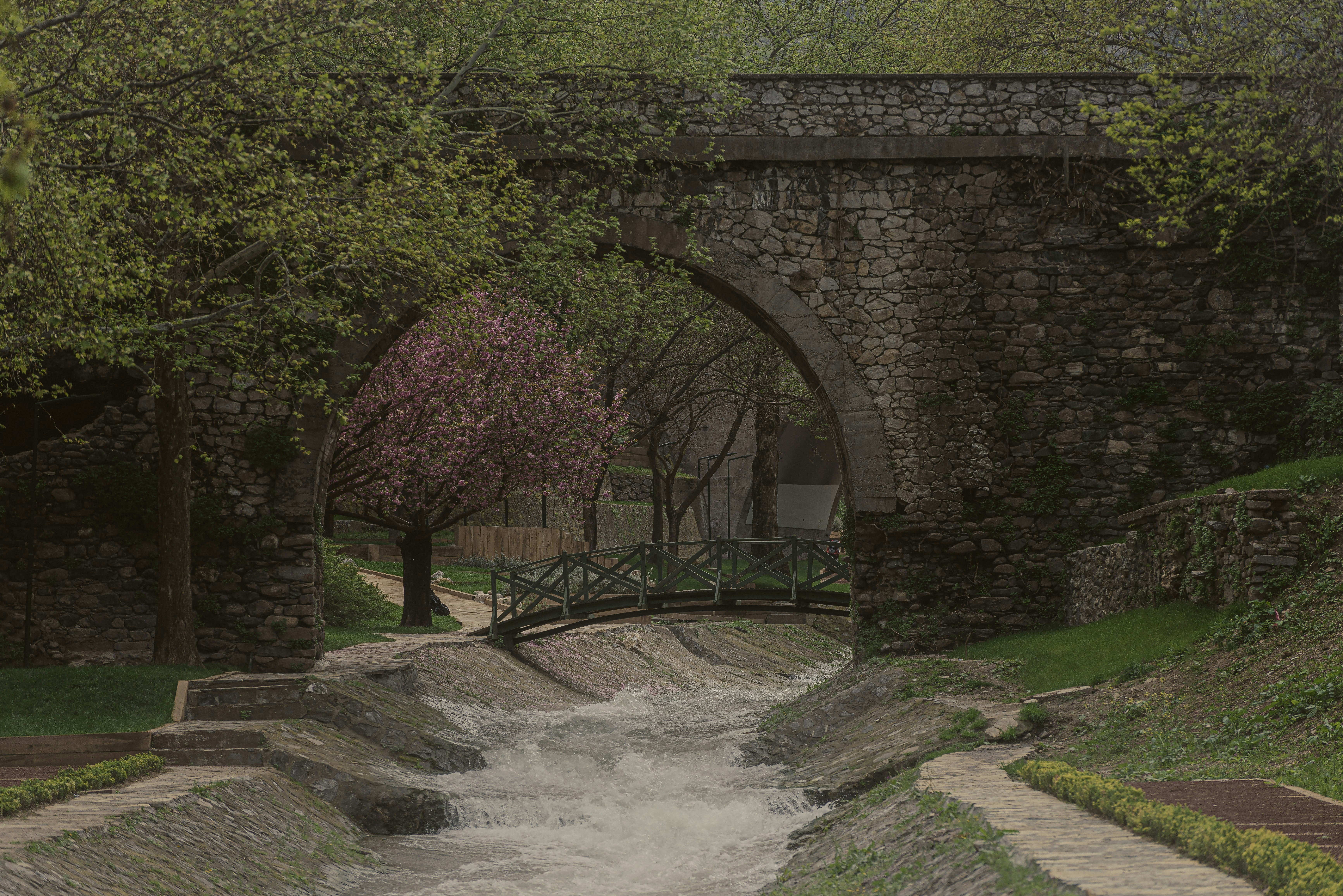 Stone Archway Over a Gentle River Path