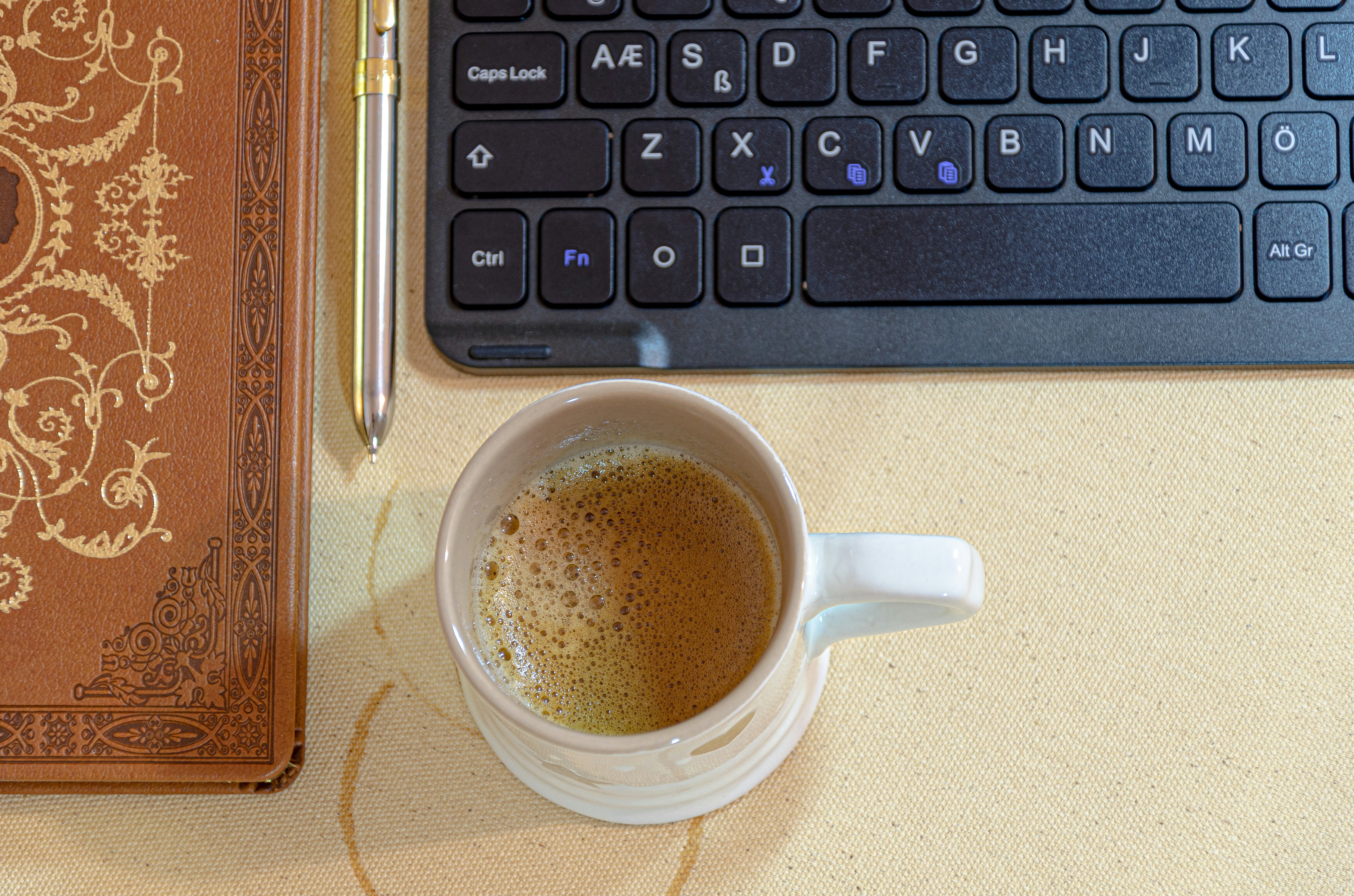Caffeinated Focus: A Laptop, Cup, and Leather-bound Quiet