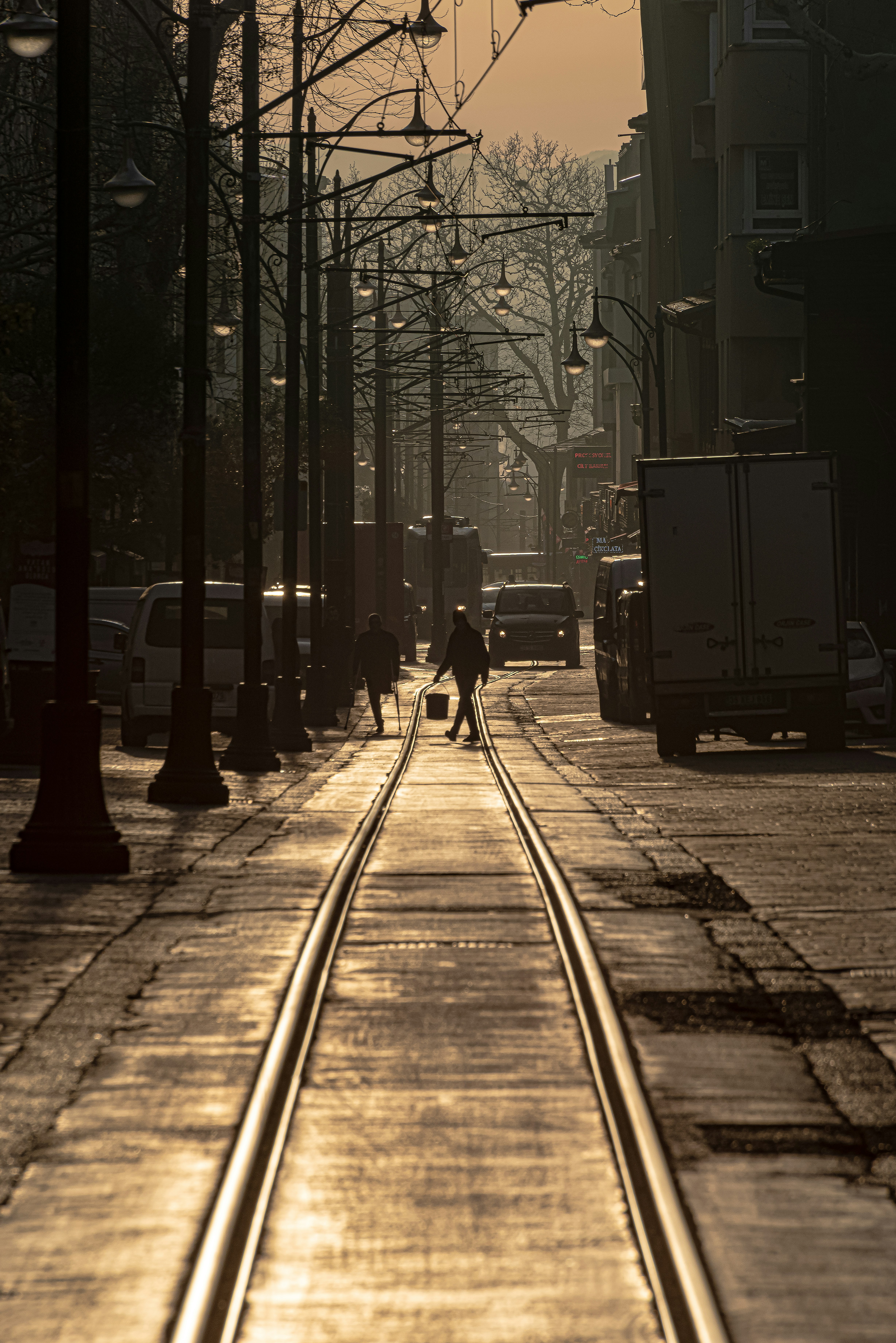 Sunlit Rails Down an Urban Street at Dusk