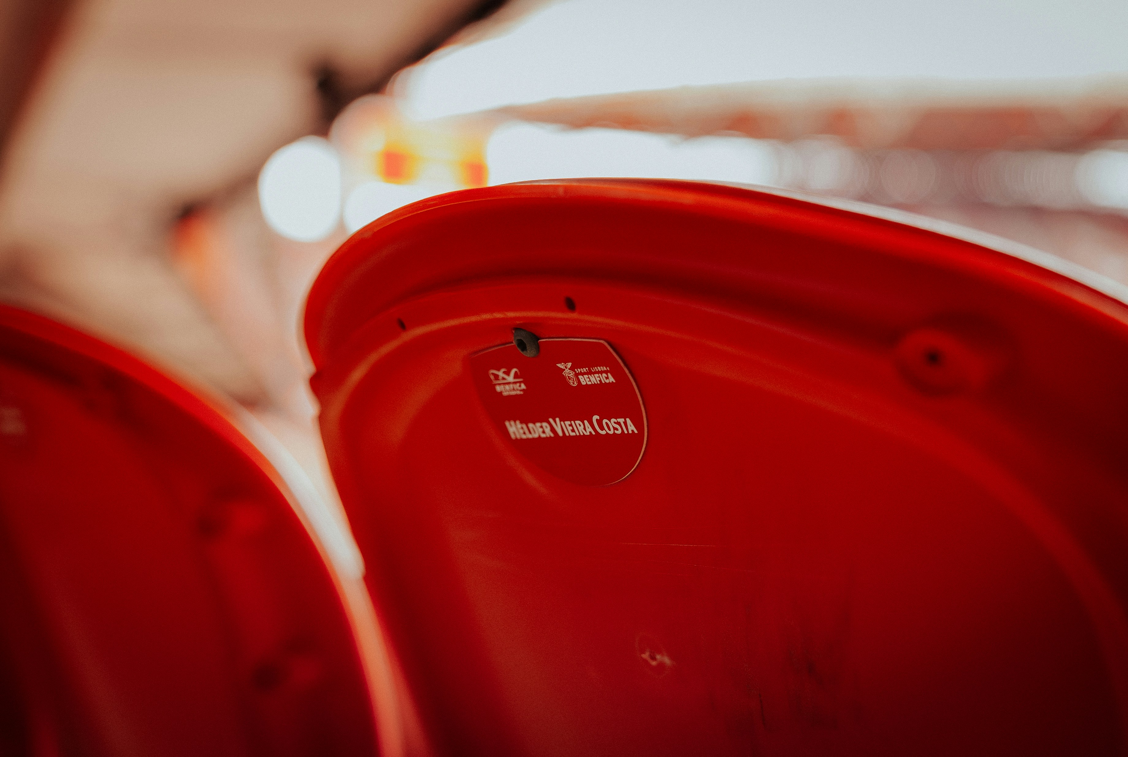 Red Stadium Seats: A Close-Up of Curved Plastic Reds in a Quiet Aisle