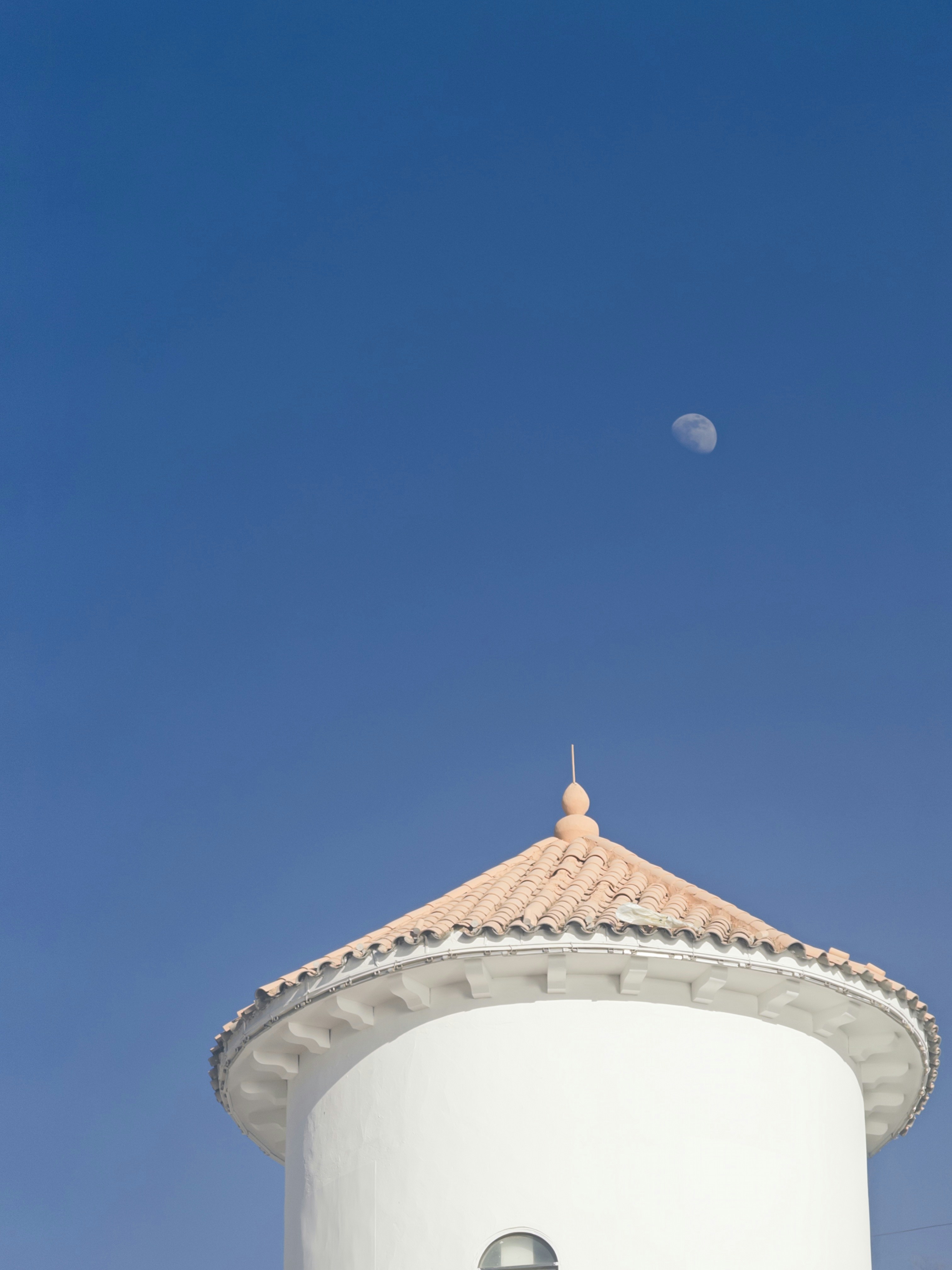 Ceramic Roof, Clear Sky: A Towering White Visage Beneath Daylight