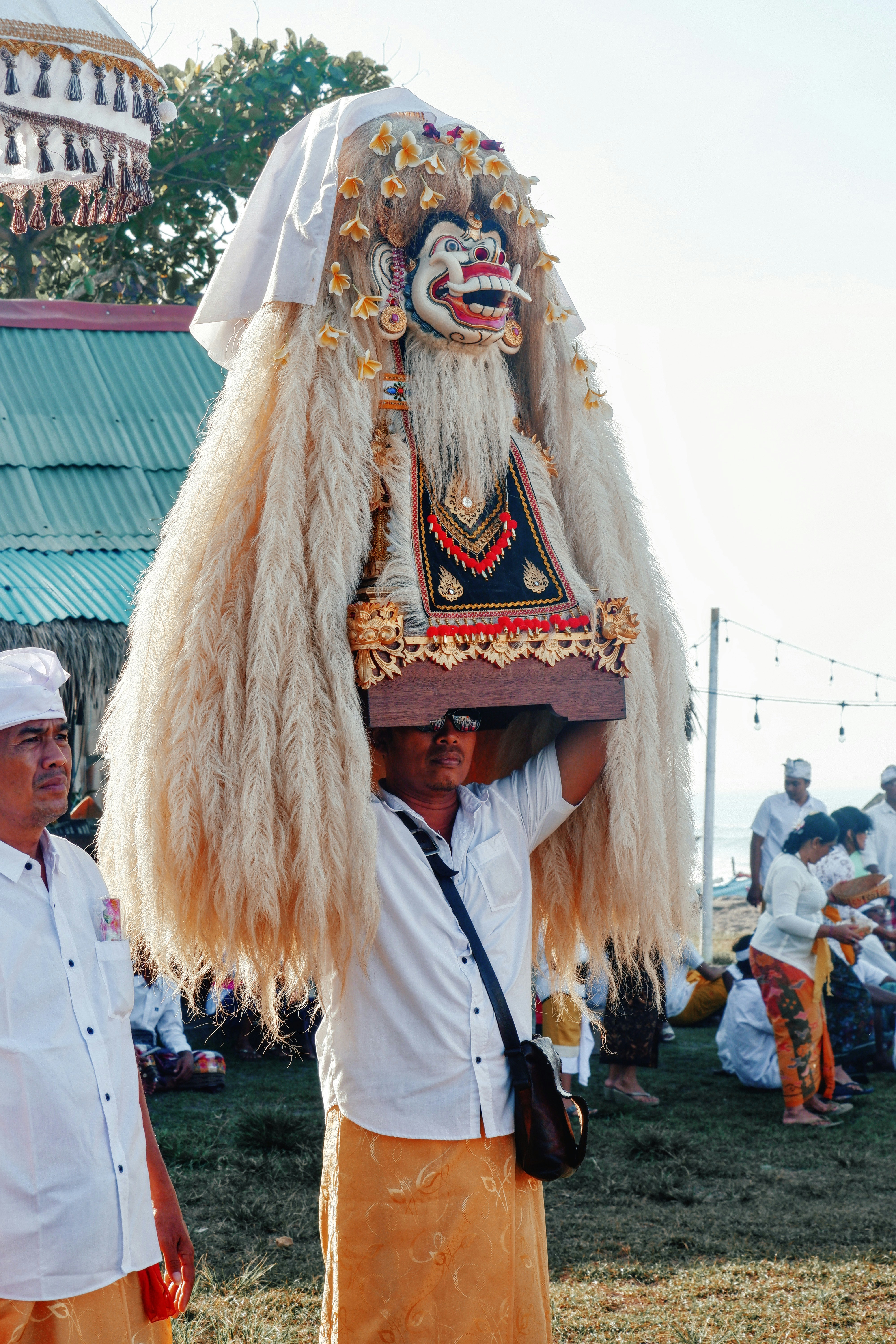 Masked Shrine Carrier at a Festive Beachside Market