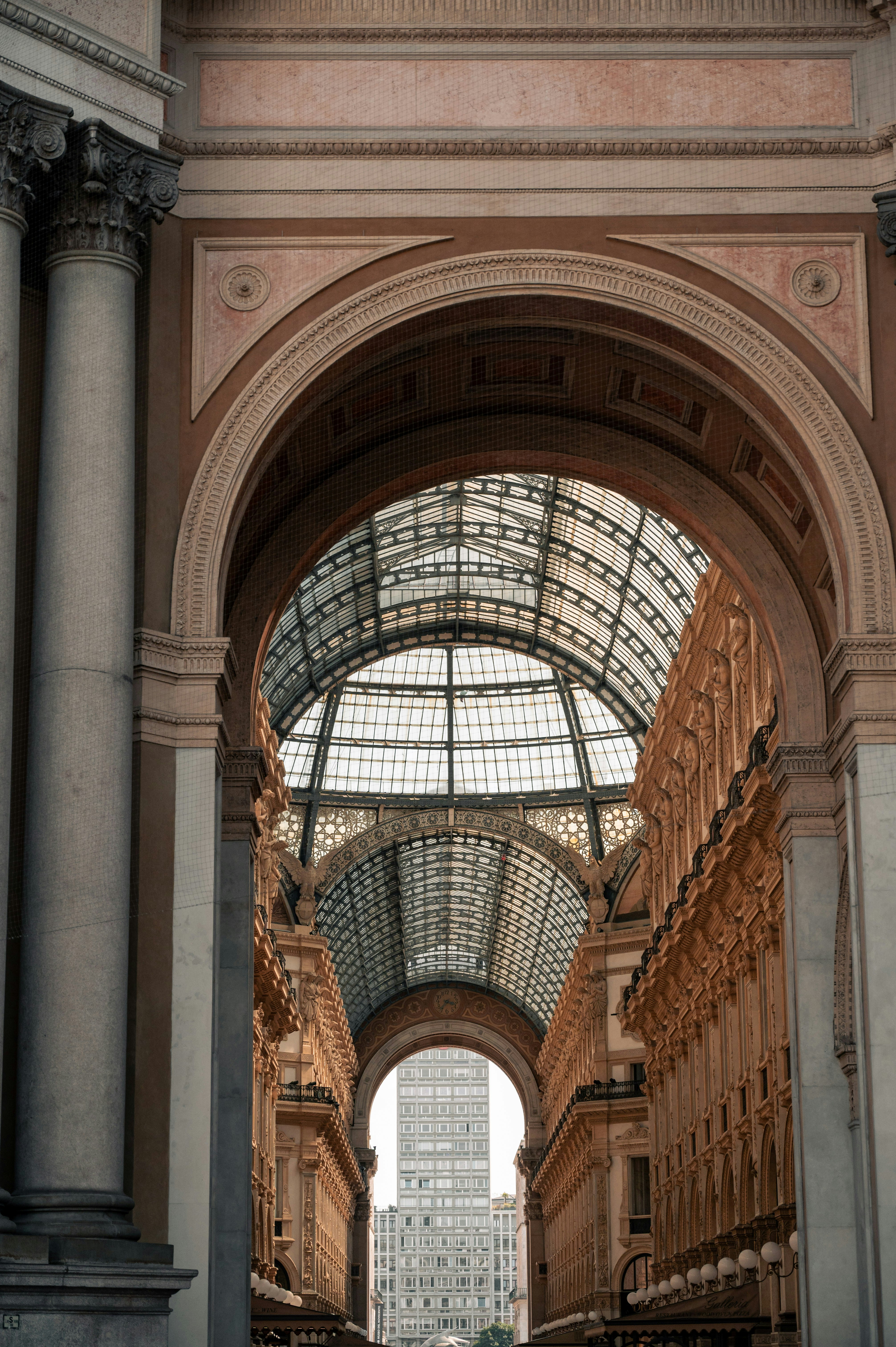 Archway to Grandeur: A Glass-Ceiling Corridor Framing a City Dell