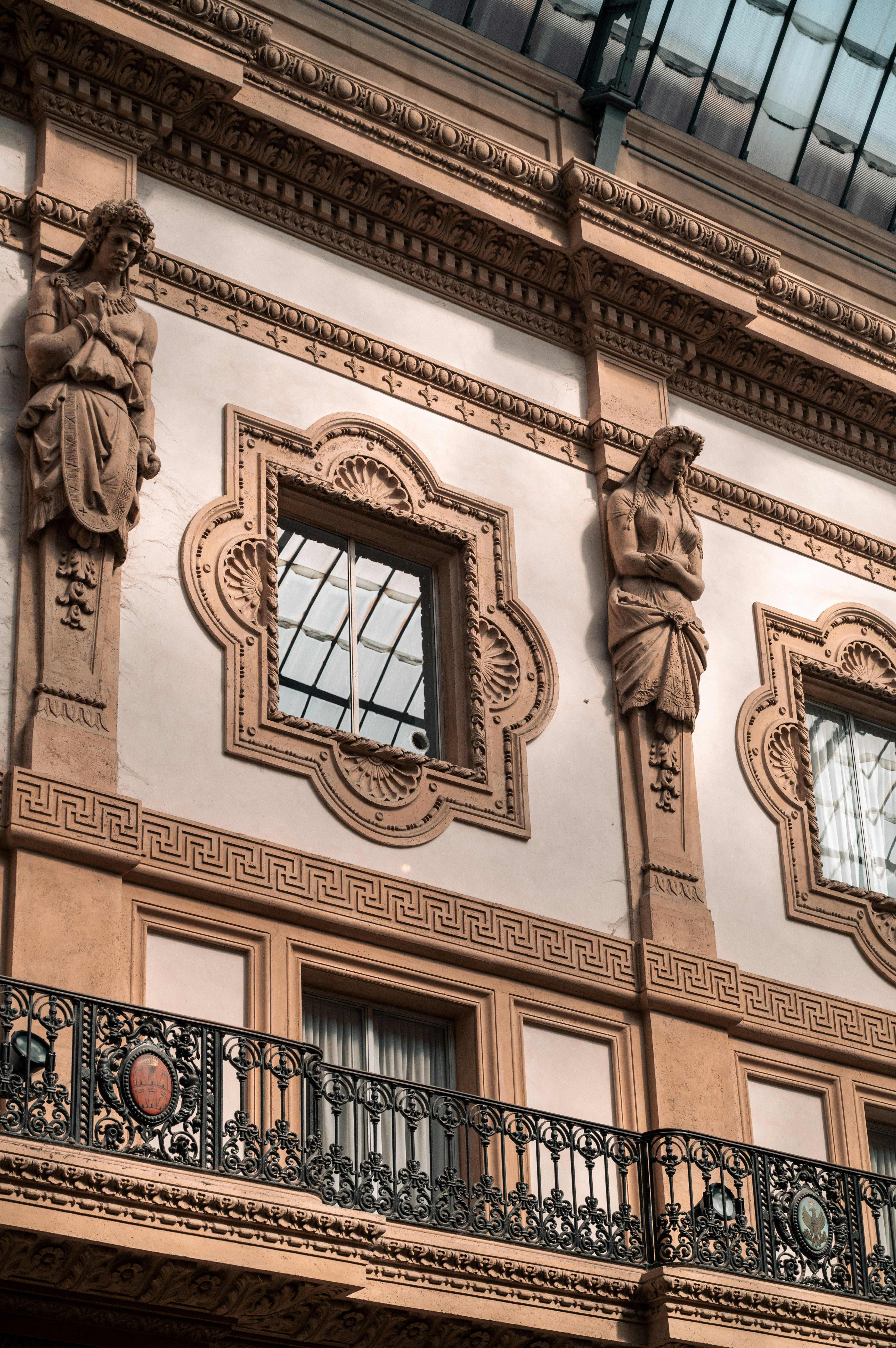 Ornate Facades: Sculpted Figures Guarding a Balcony of Carved Windows