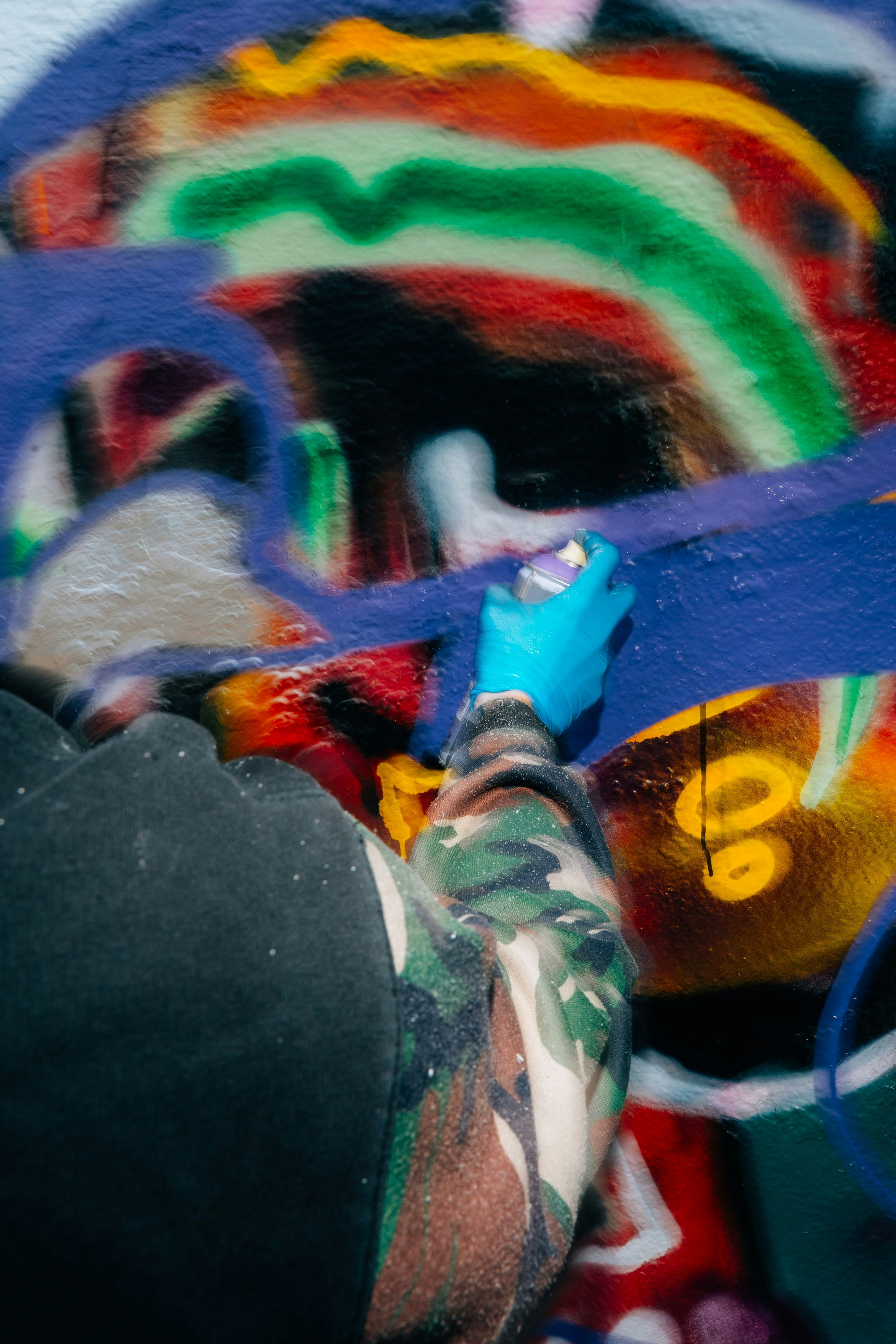 Midnight Indigo: A Gloved Hand Sprays Color into a Neon Wall