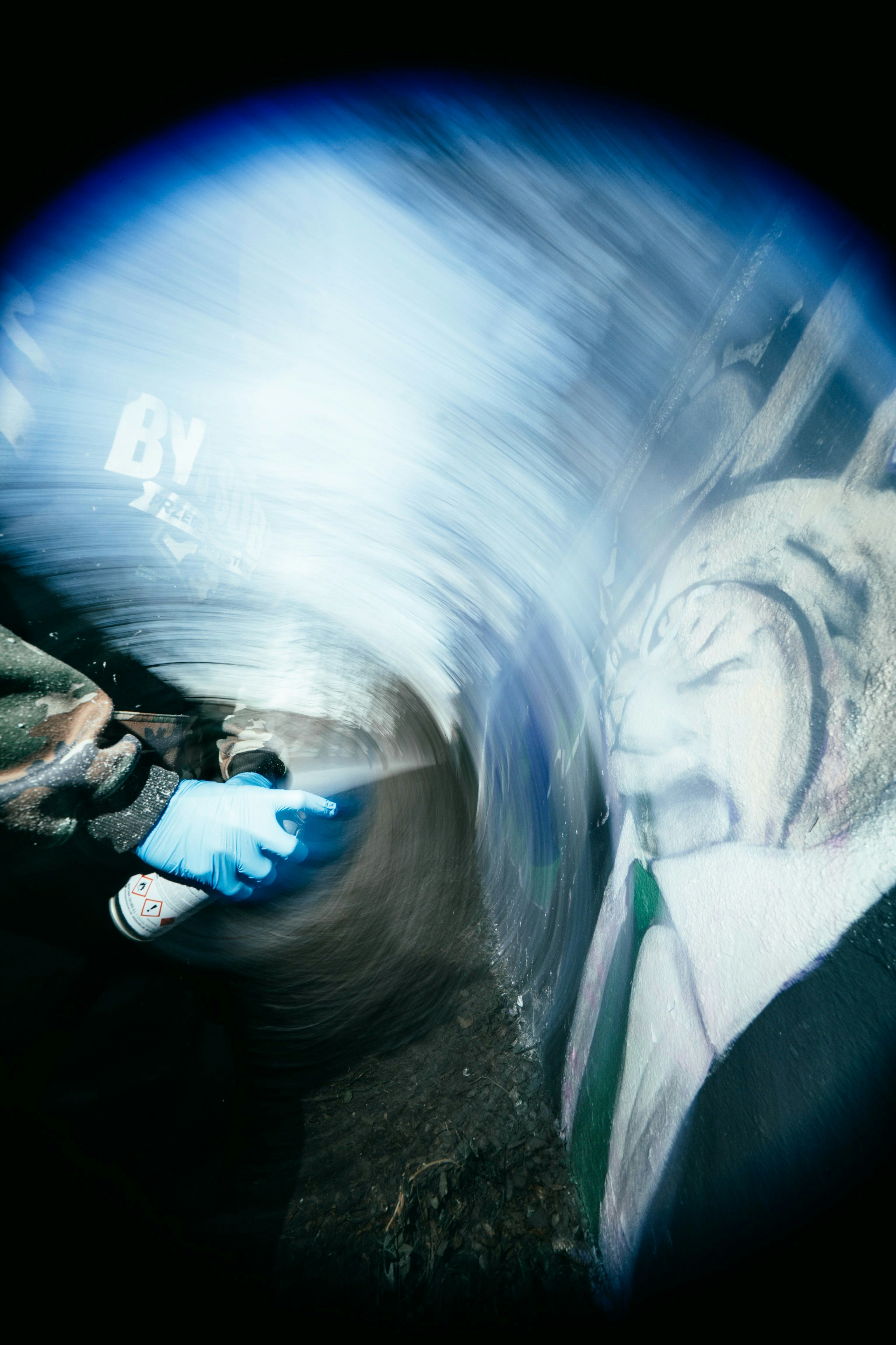 Blurred Motion: Hand and Spray in a Distorted Graffiti Scene