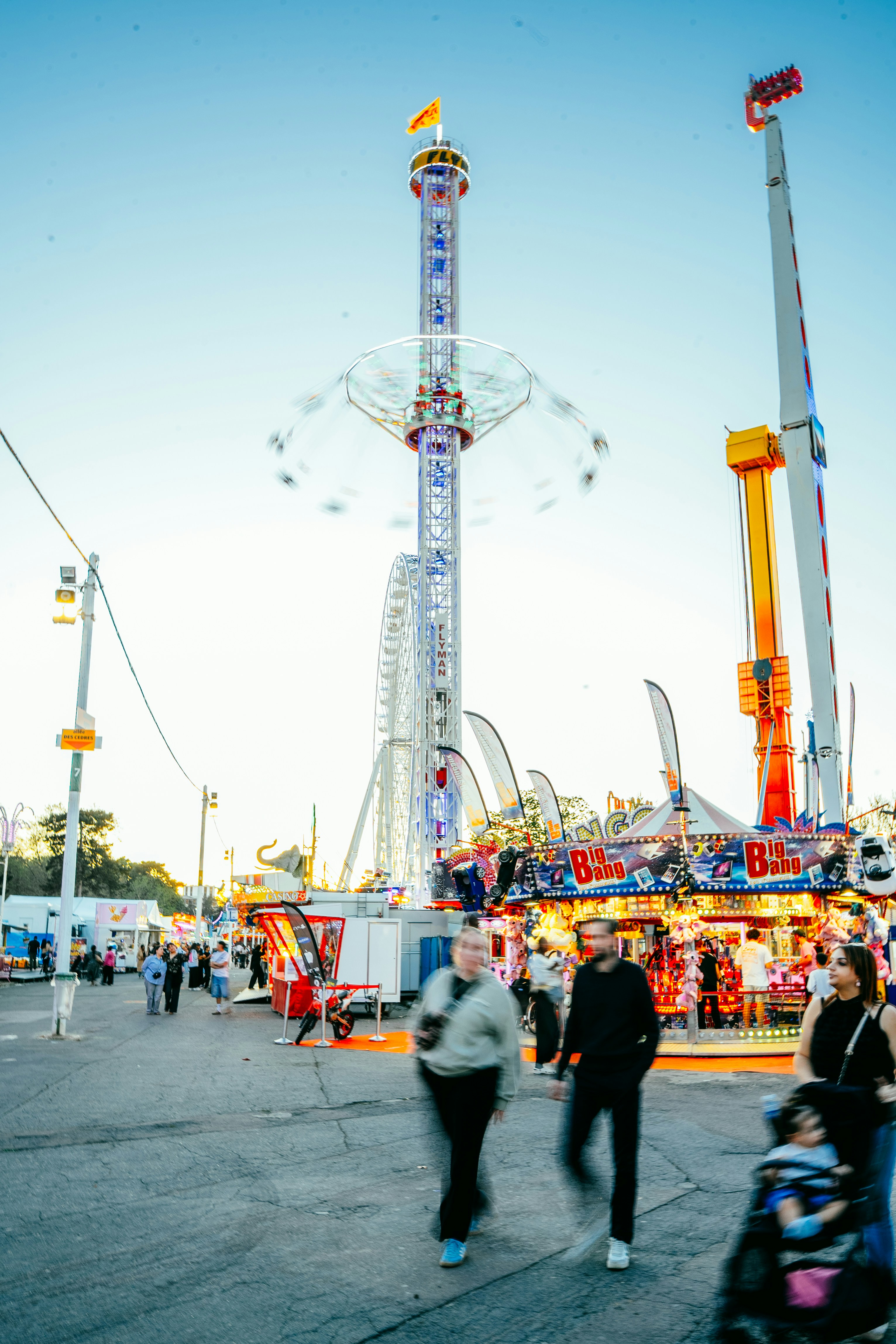 Ferris Wheel in Motion Above a Lively Fairground at Dusk