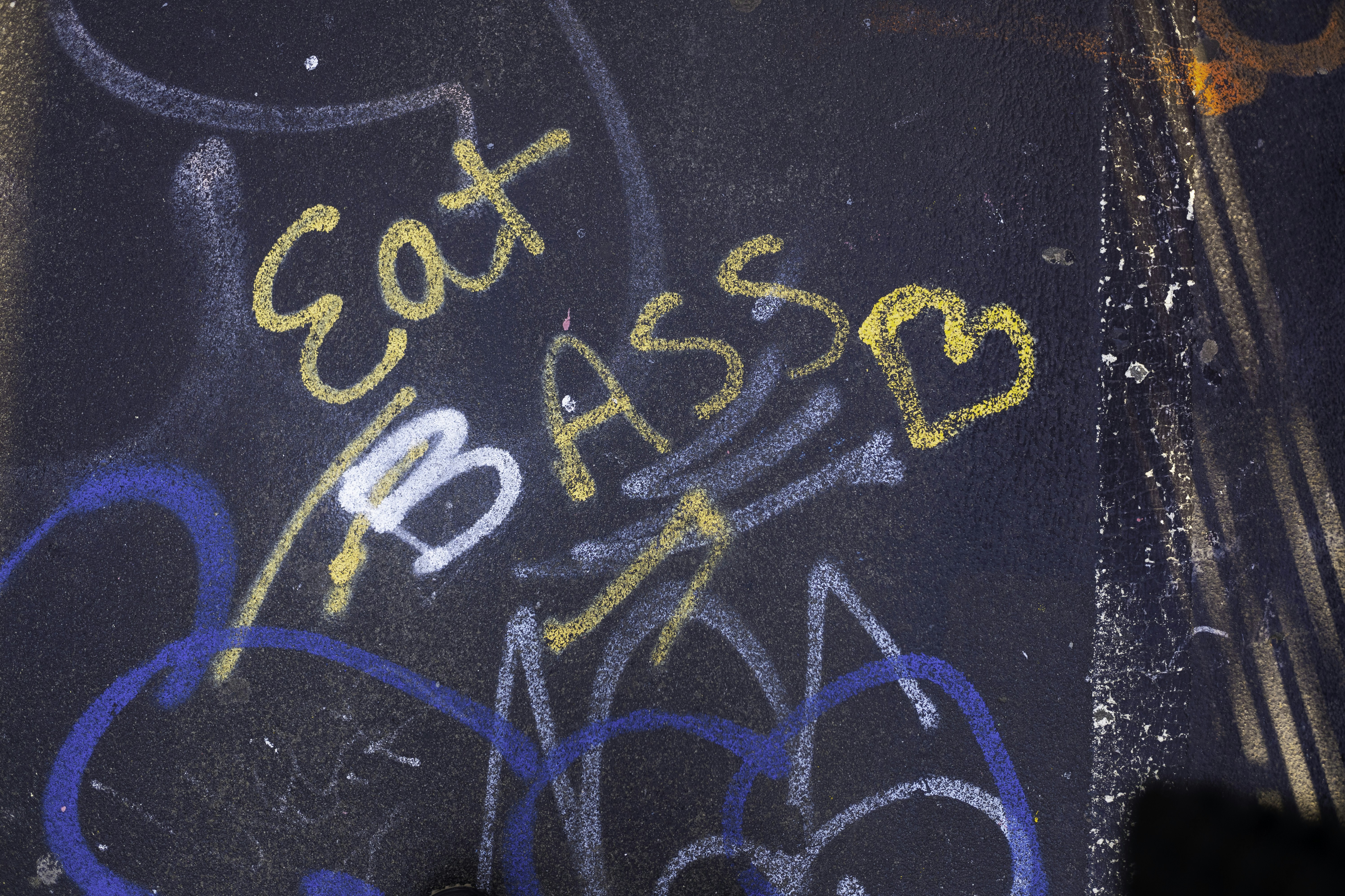 Graffiti Heartbeat: Yellow Script Amid Blue Outlines on Night Cement