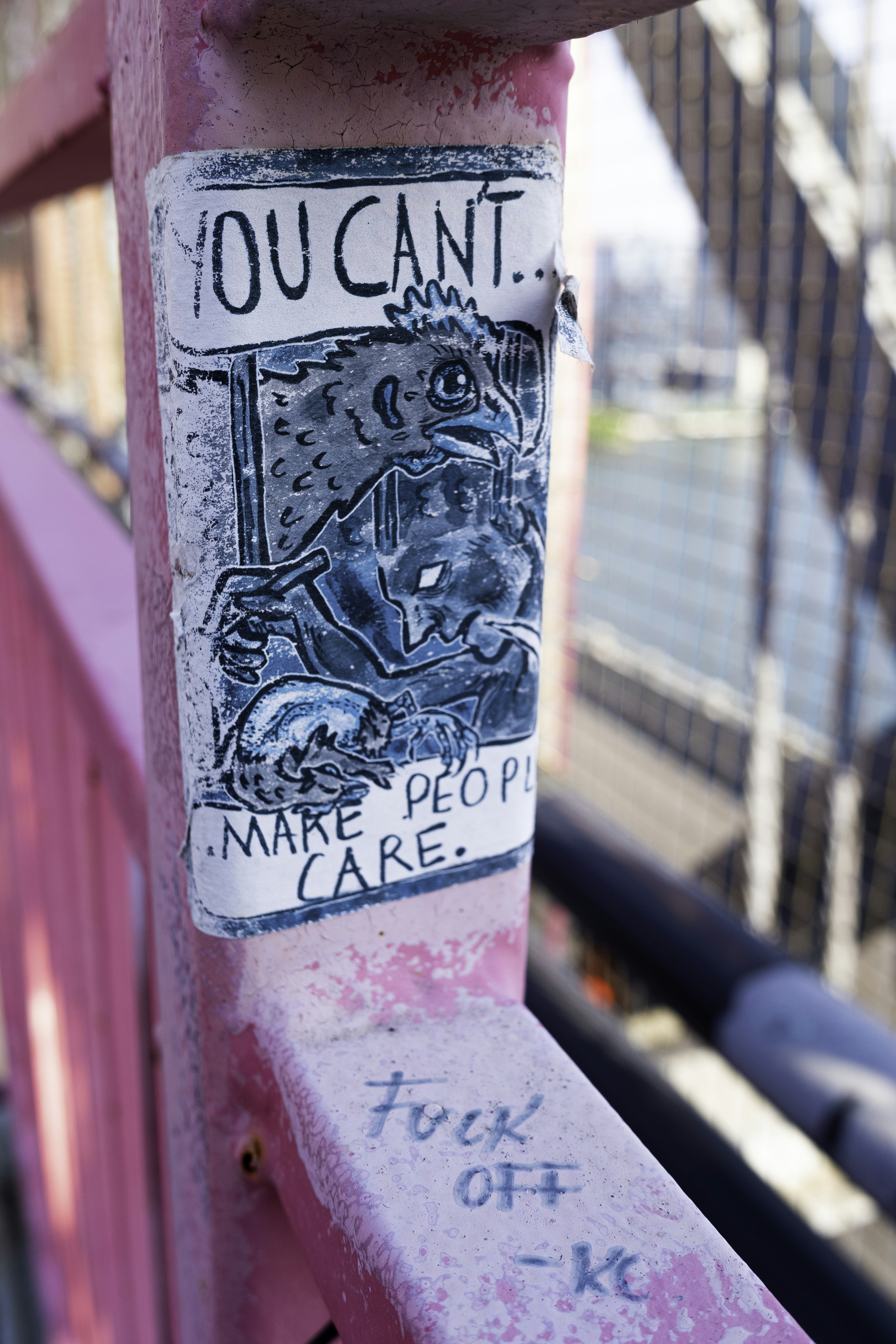 Graffiti Sticker on a Pink Rail: A Message in Color and Texture