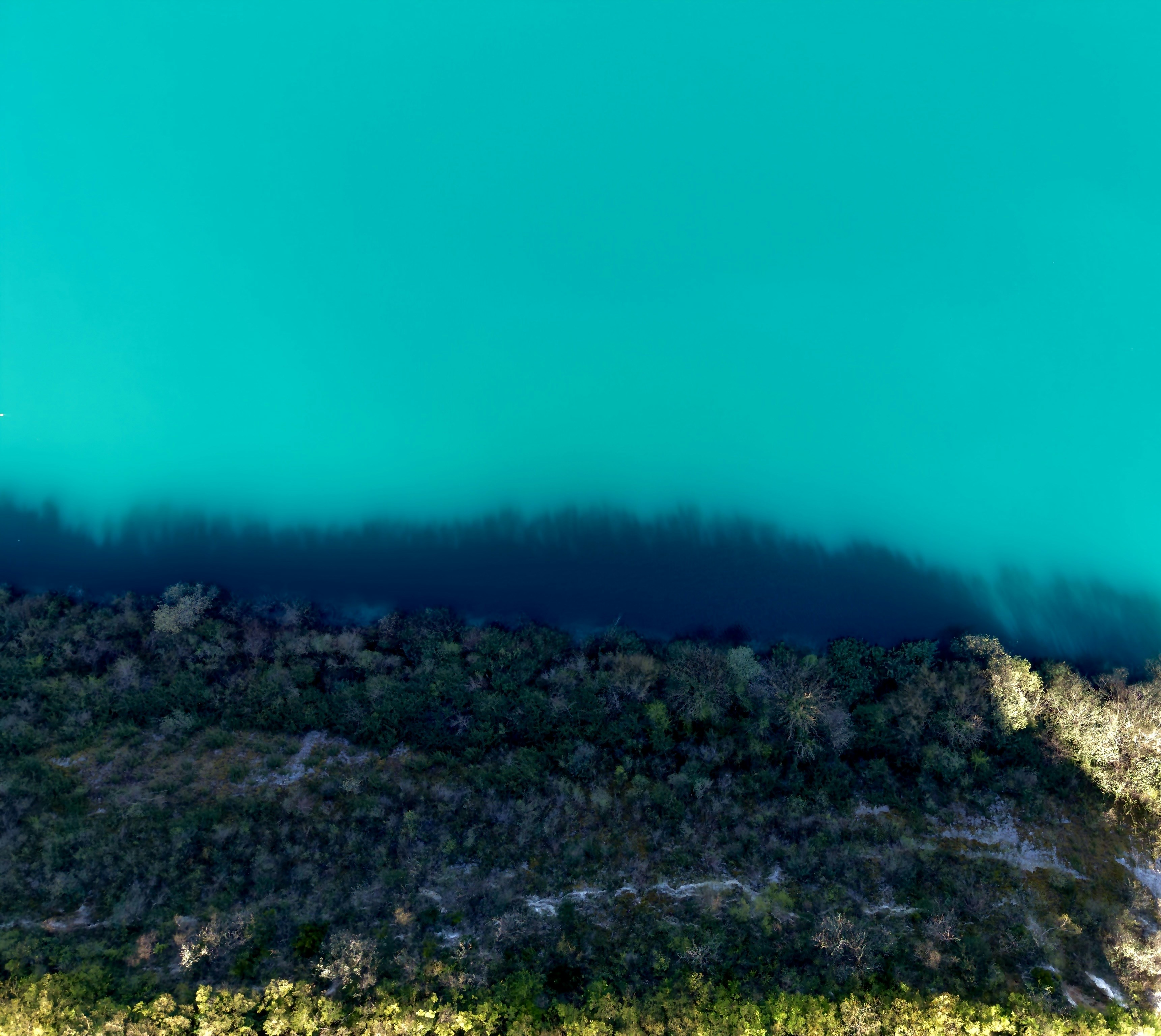 Ceiling of turquoise sky over a shadowed coastal ridge