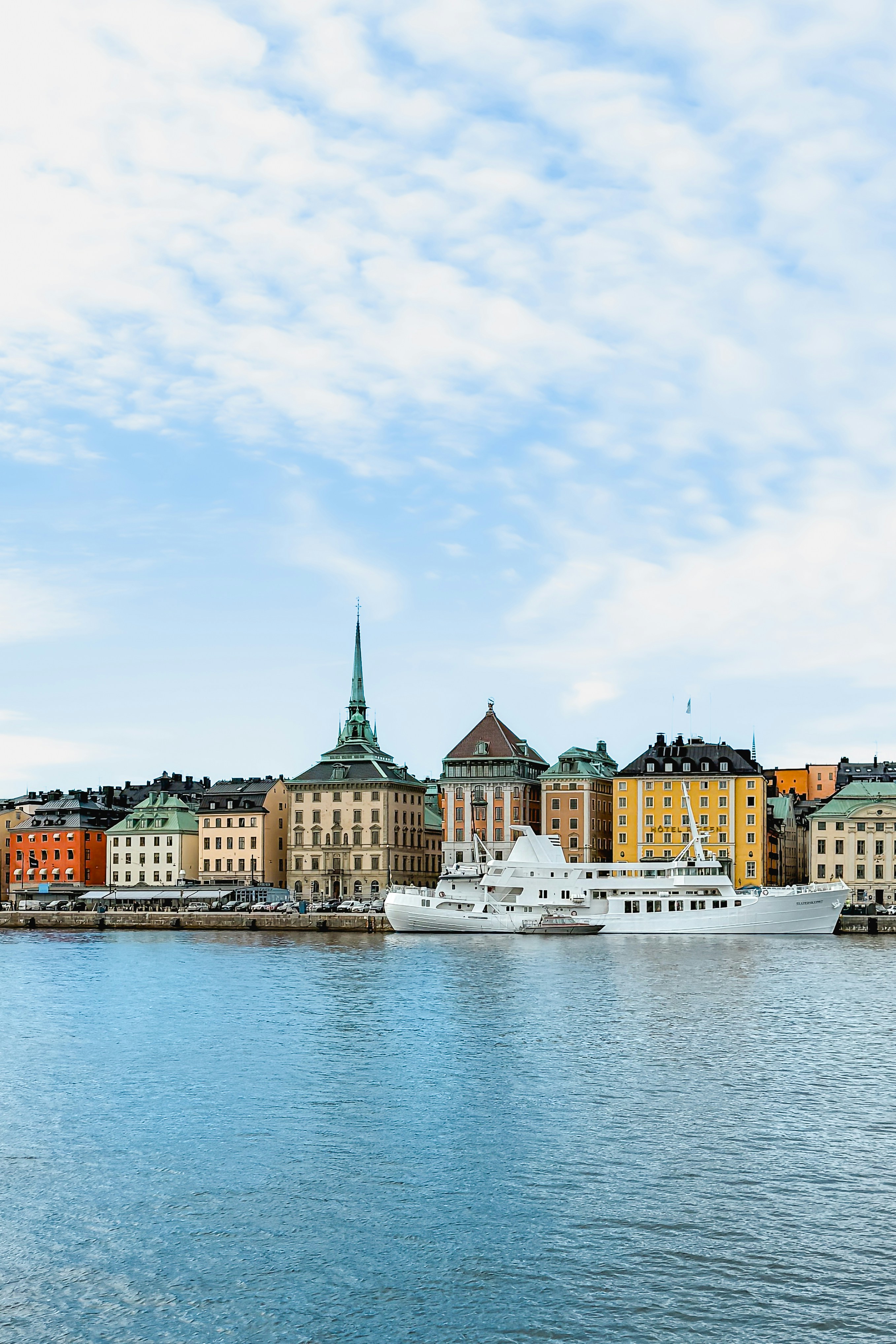 Harborfront Panorama: Colorful Townhouses and a White Yacht