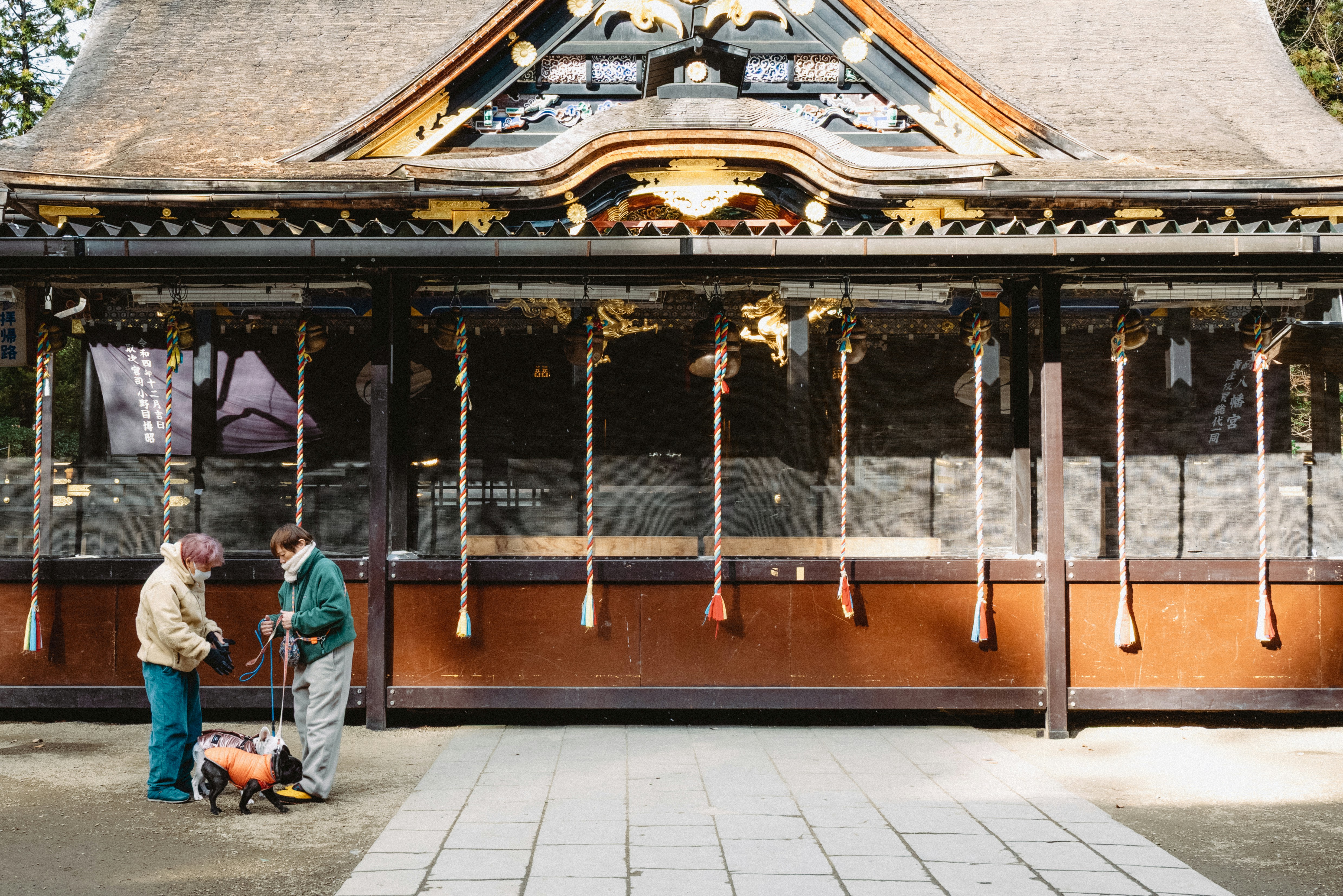 Two Visitors in Quiet Exchange Before a Sacred Facade