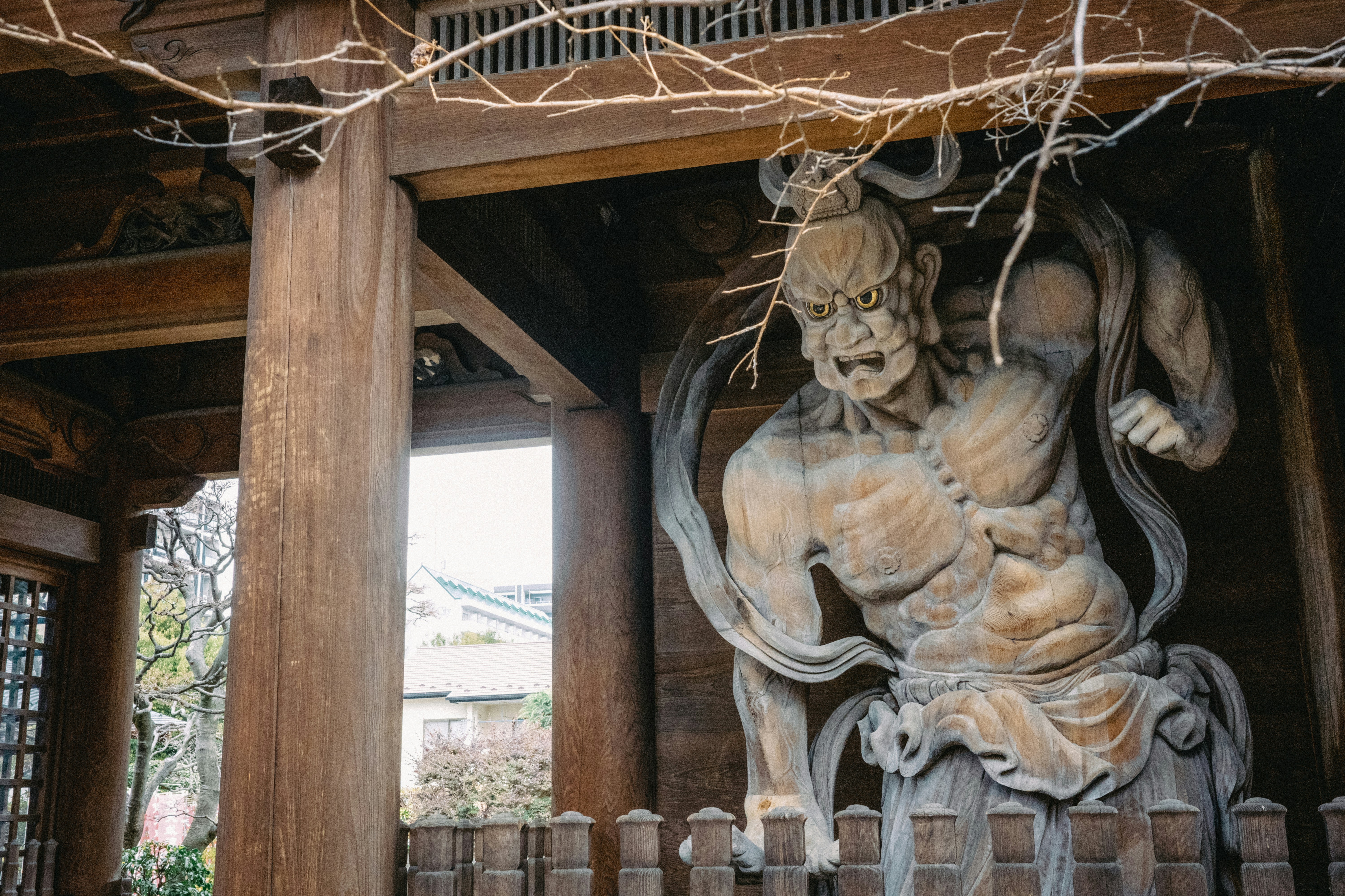 Guardian In Wood: A Weathered Demon Statue at Dusk