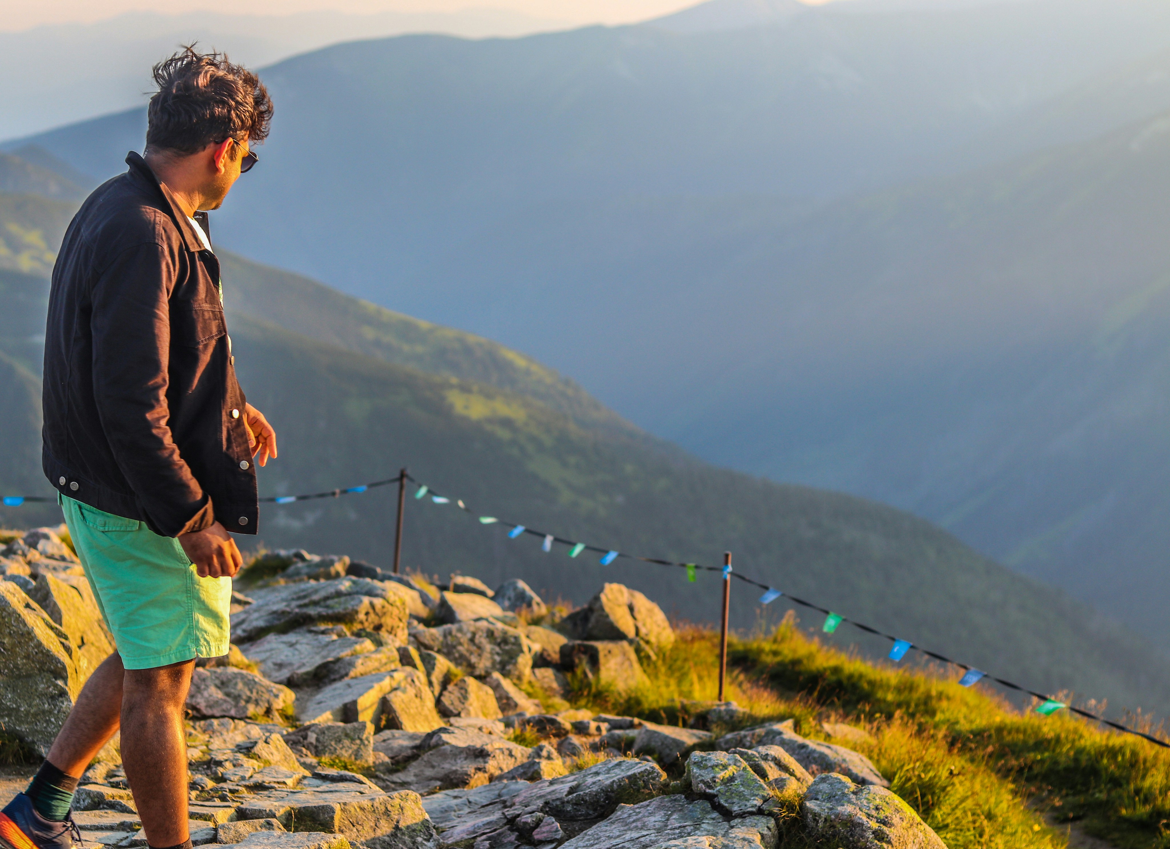 Trailbound: A Wanderer Stands on a Mountain Ridge at Dusk