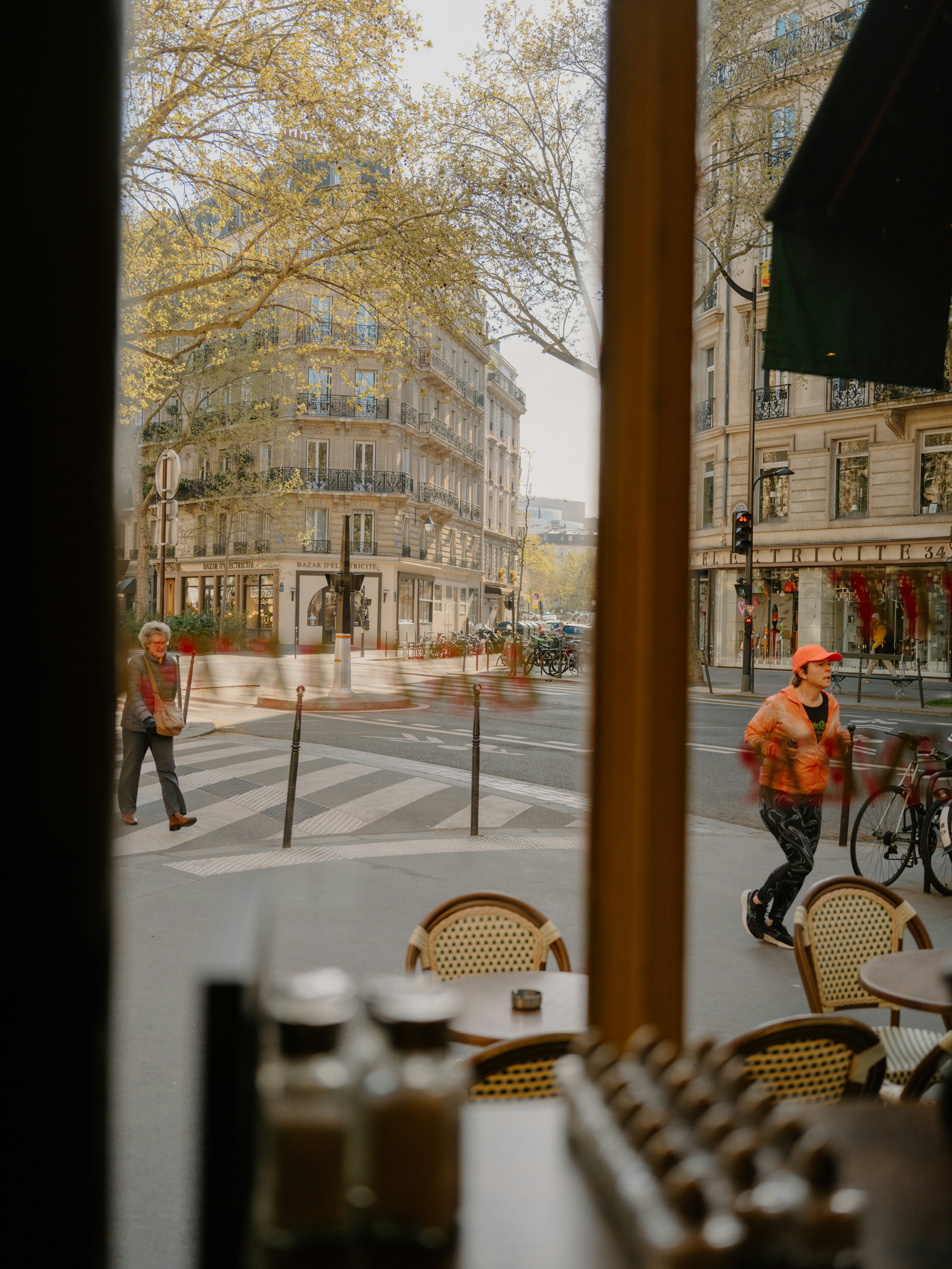 Windowed Street Scene: A Moment Between Cafè Tables and Crossing Pedestrians
