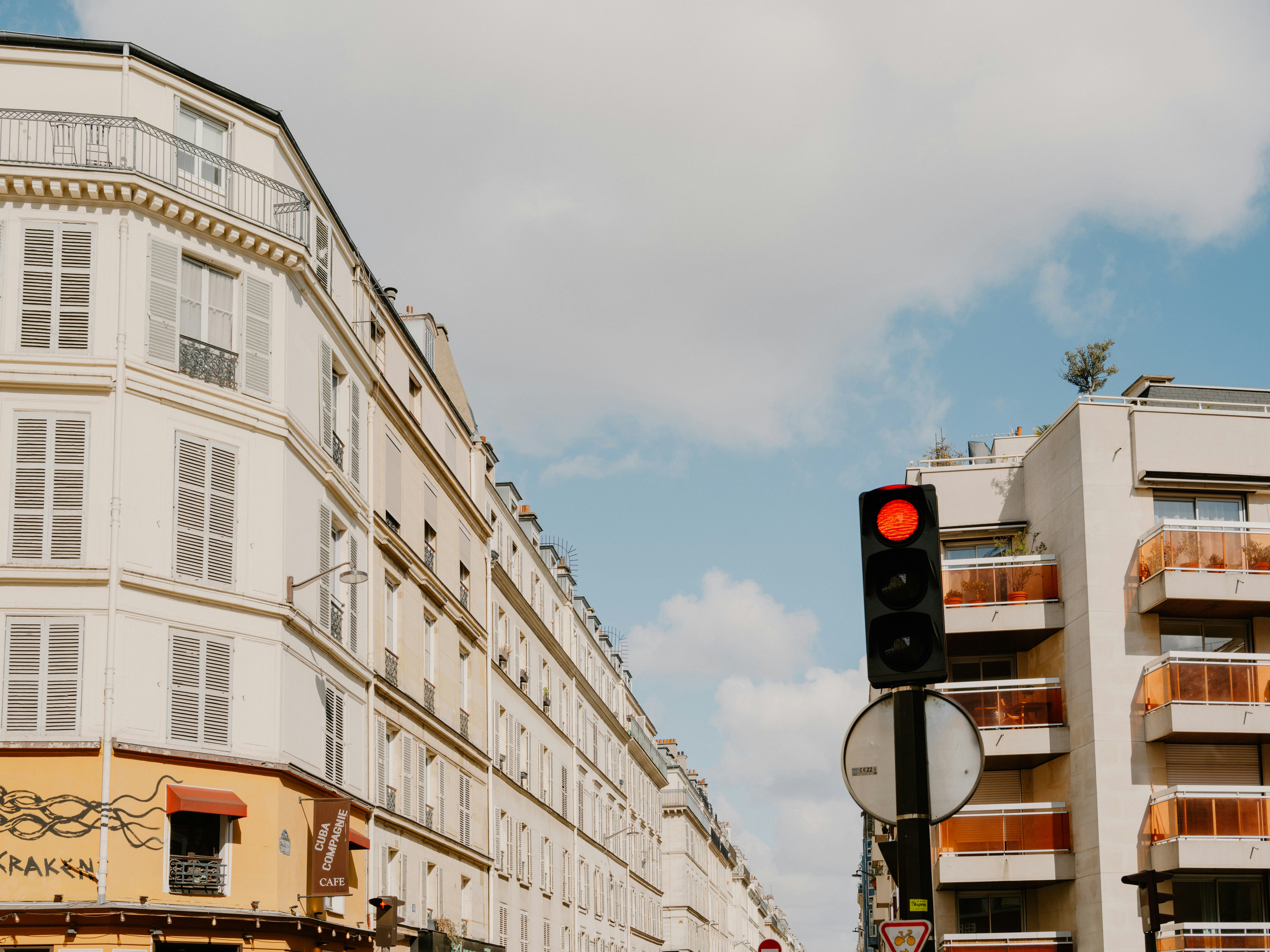 Crossing Quiet Boulevard: Red Traffic Light Over a Parisian Street