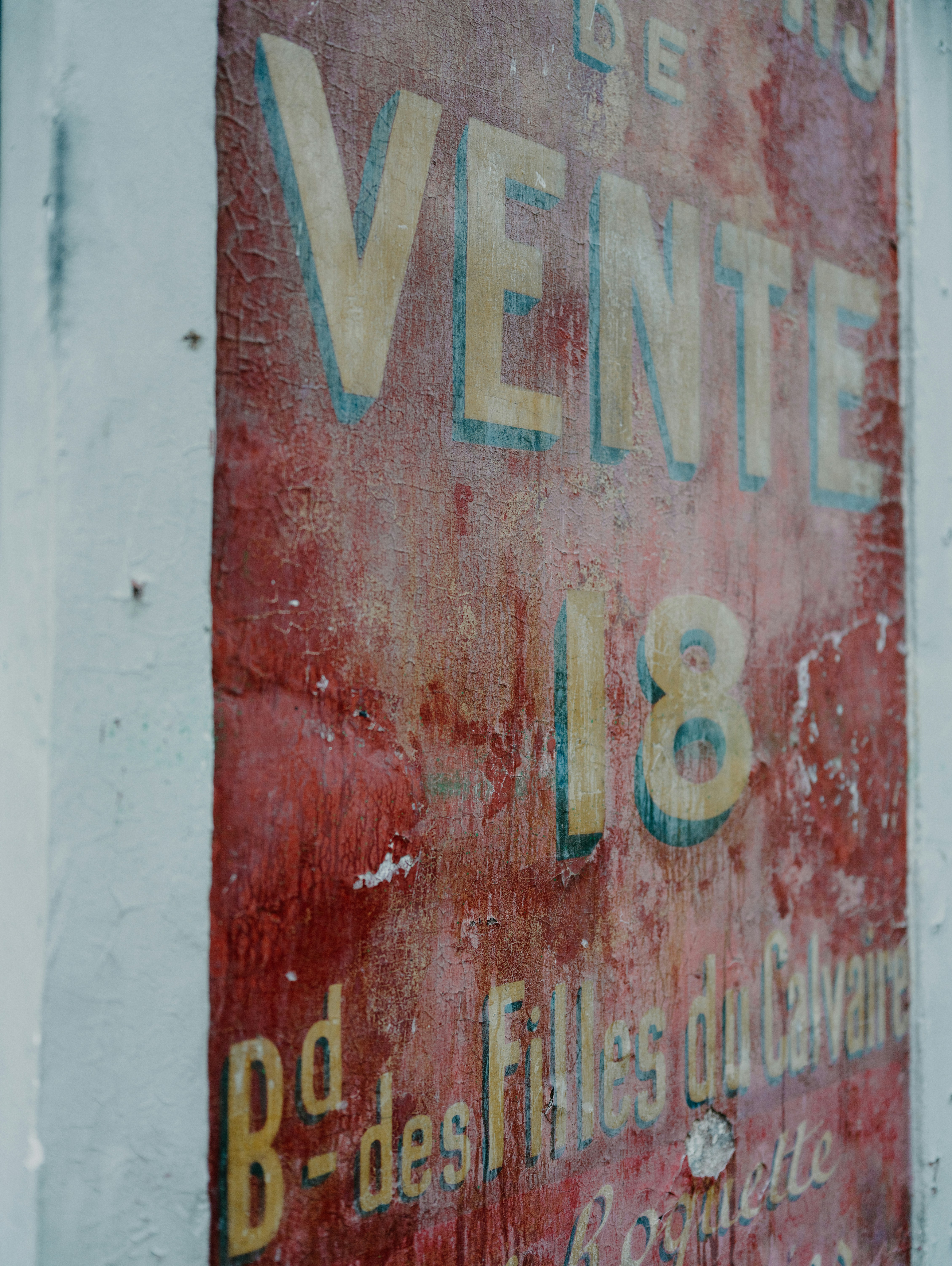 Weathered signage in a chipped red doorway