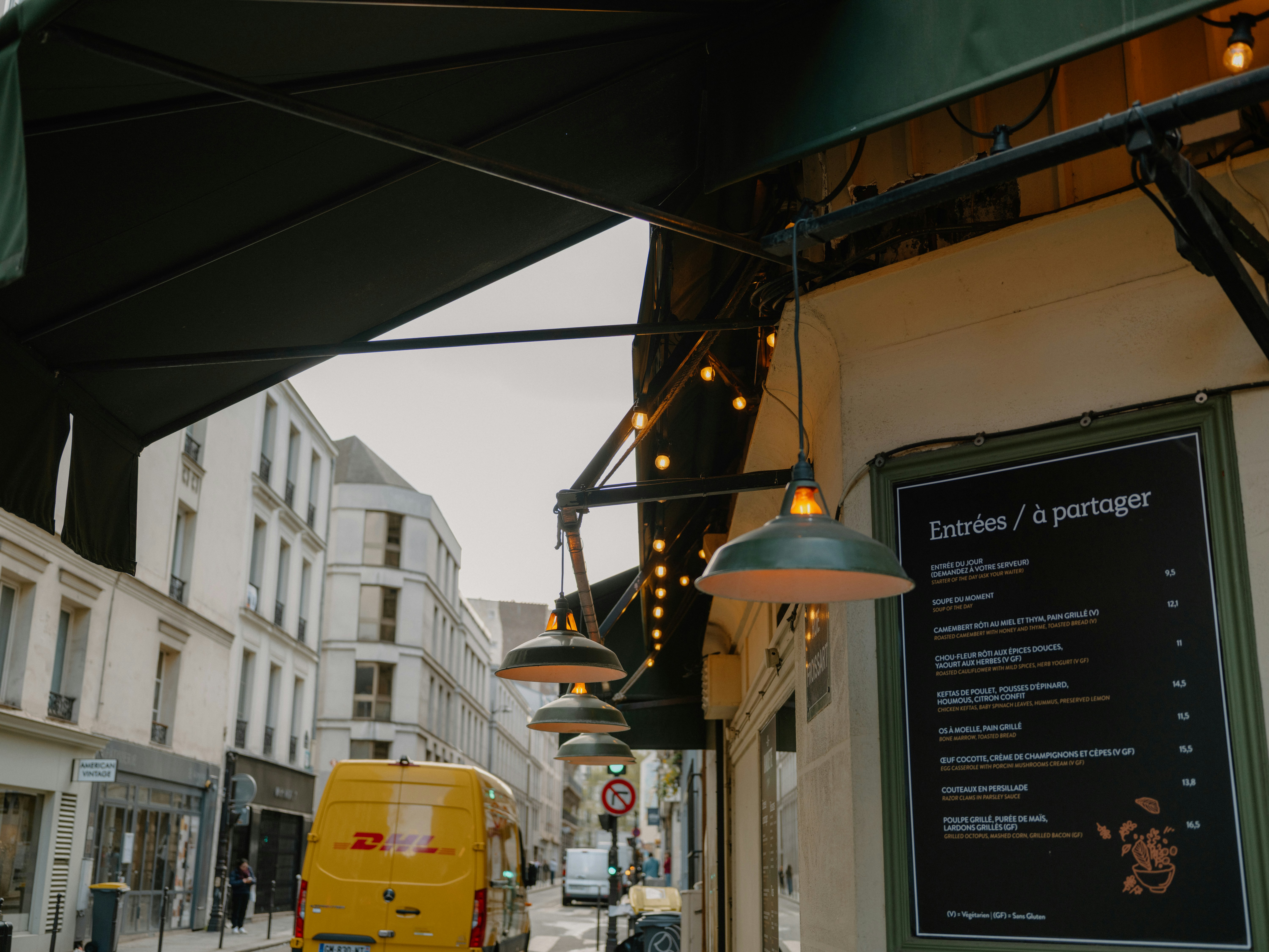 Parisian Café Façade: Evening Light Beneath Striking Green Awnings