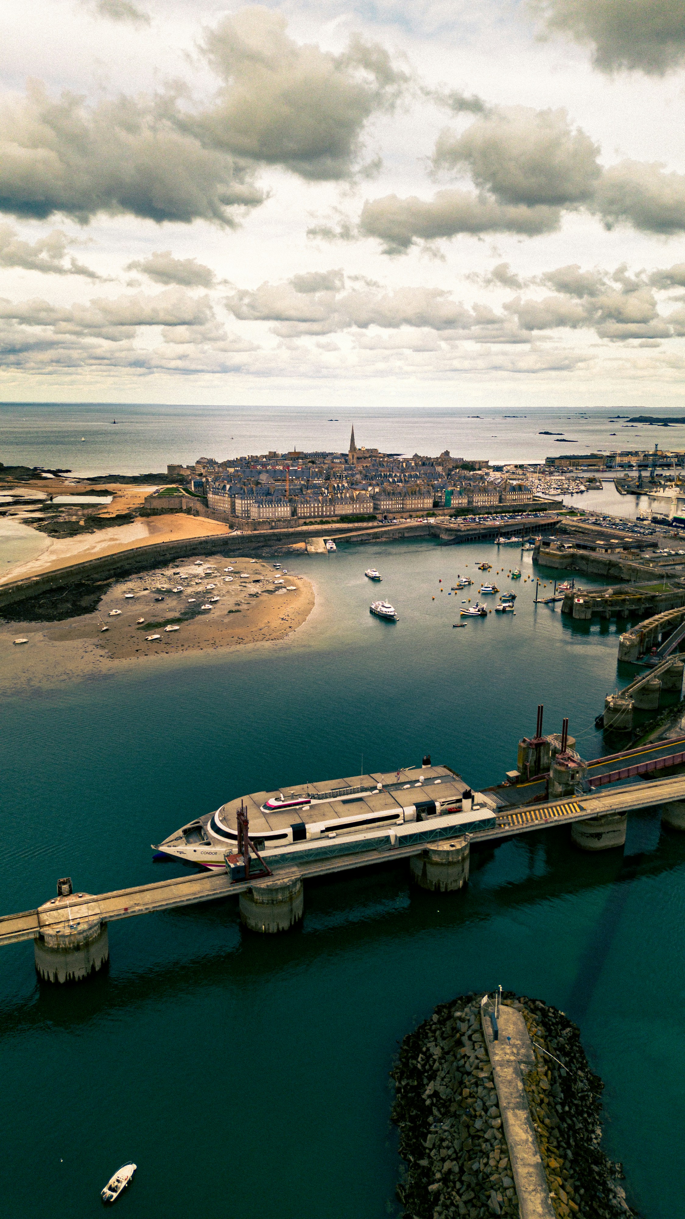 Harbor Arc: Aerial View of a Coastal Town with Pier and Boats