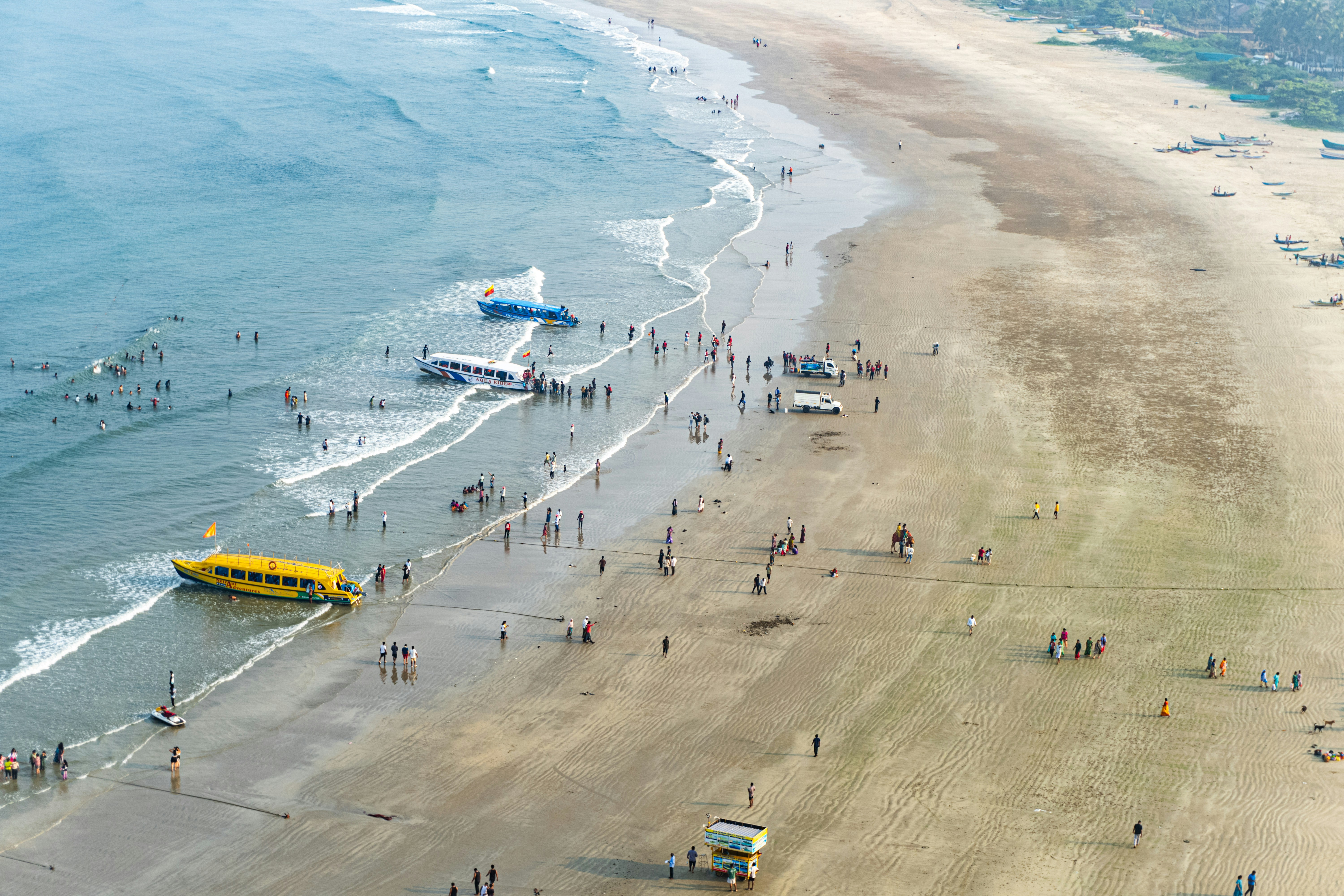 Shimmering Shoreline: Aerial Tapestry of People and Boats