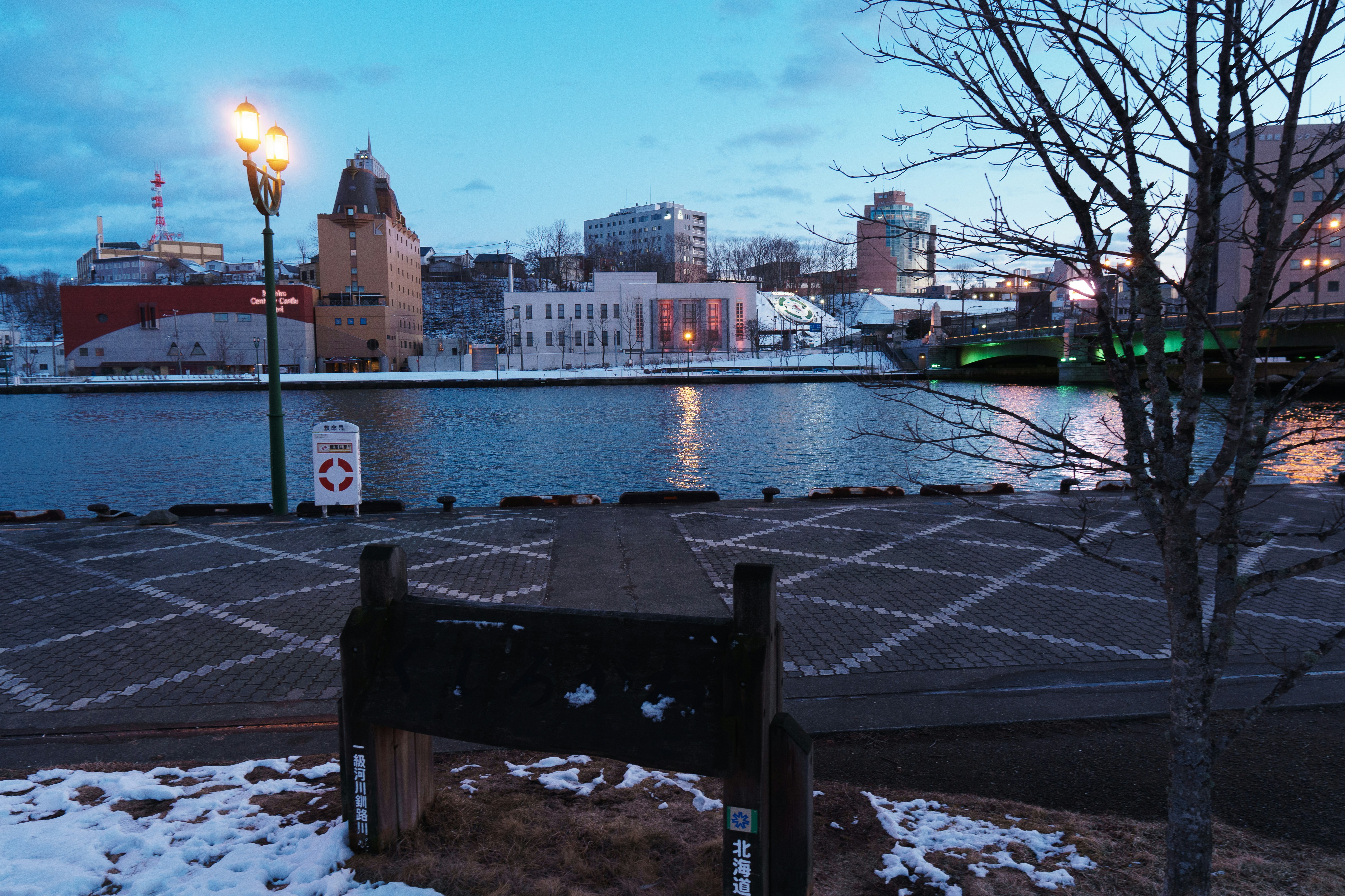 Winter Waterfront Where City Lights Reflect on Calm Frozenevening