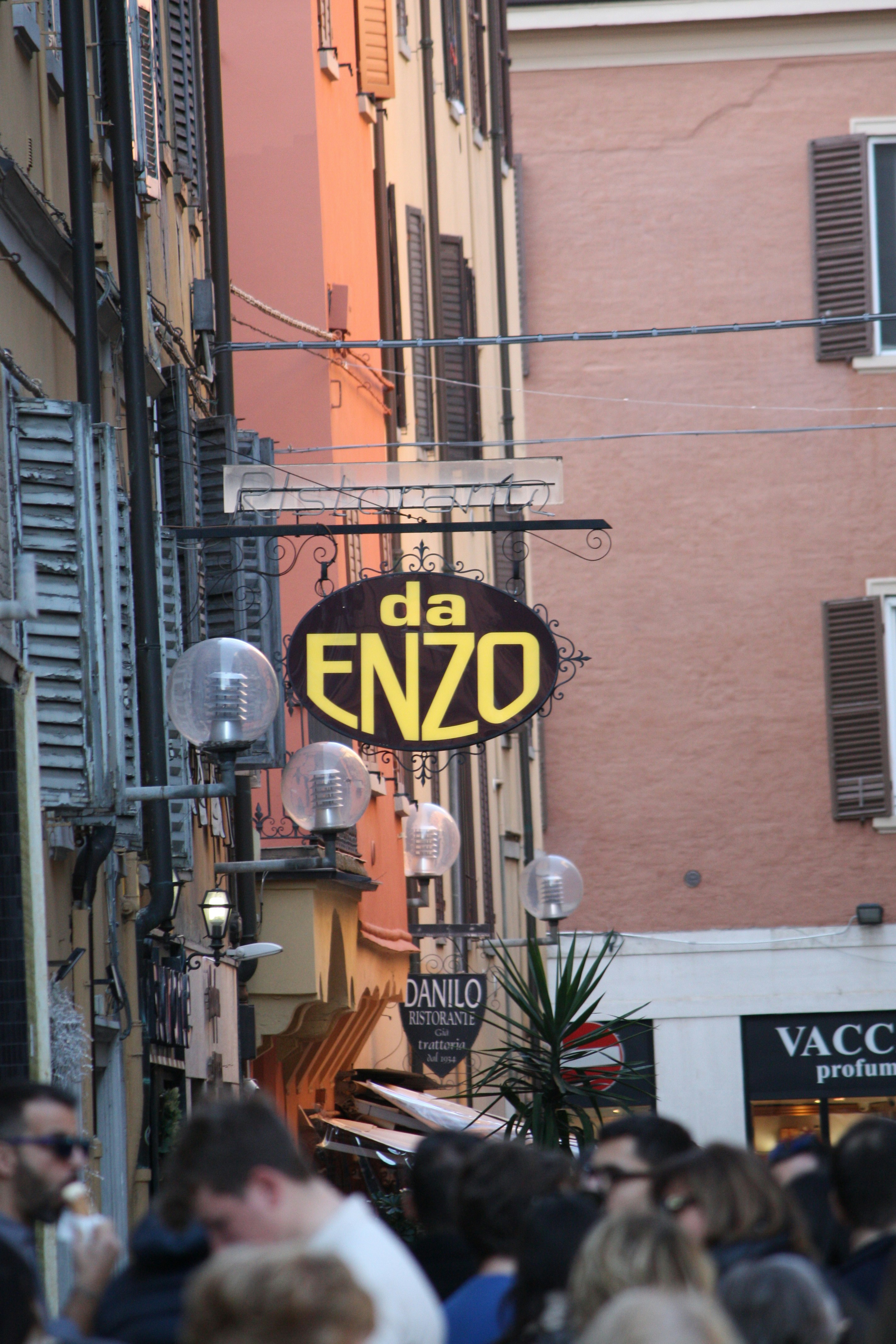 Signage and street life: a crowded Italian alleyway under warm tones