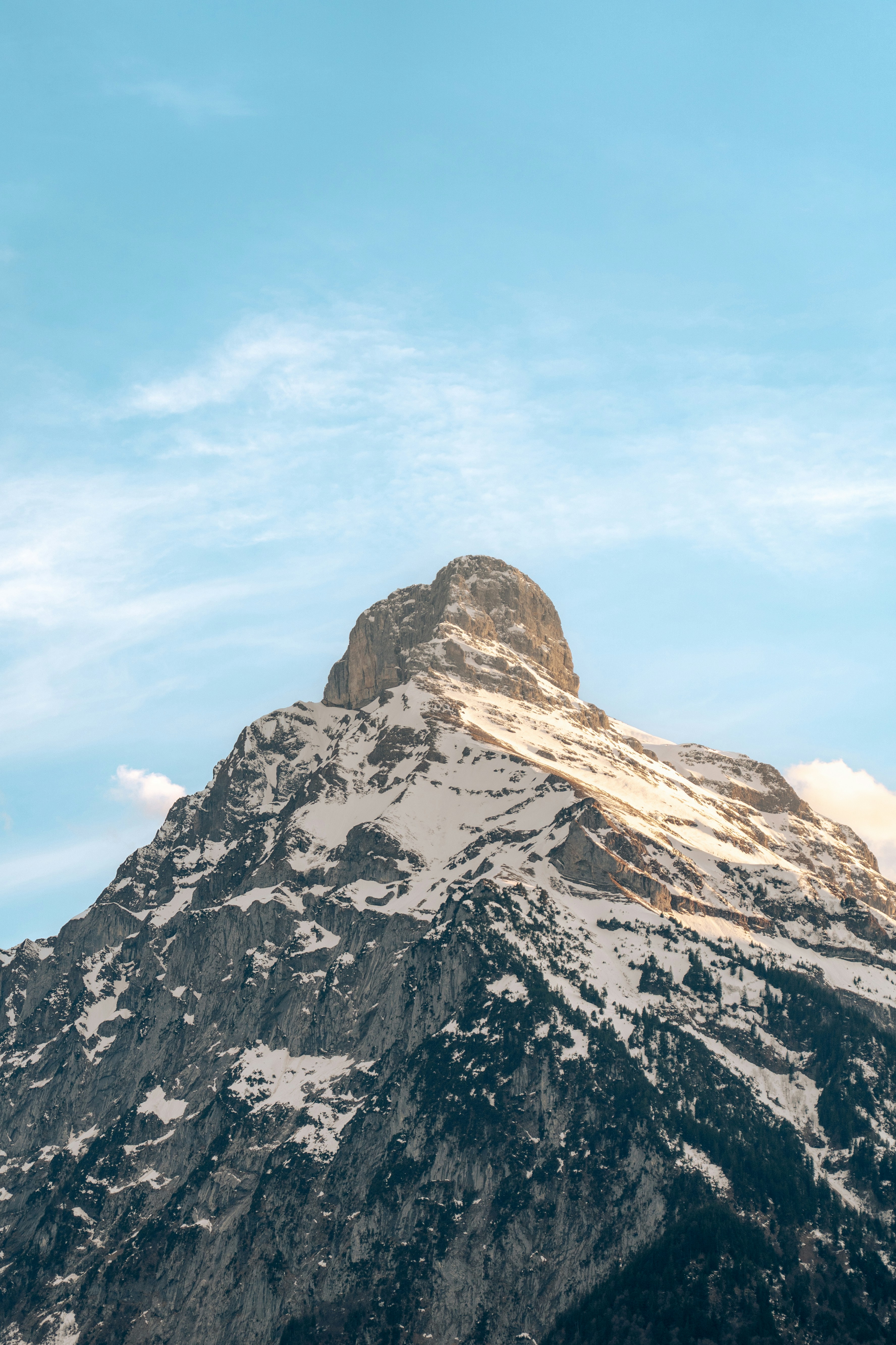 Summit Crown: A Snow‑kissed Peak Beneath a Clear Gulf of Sky
