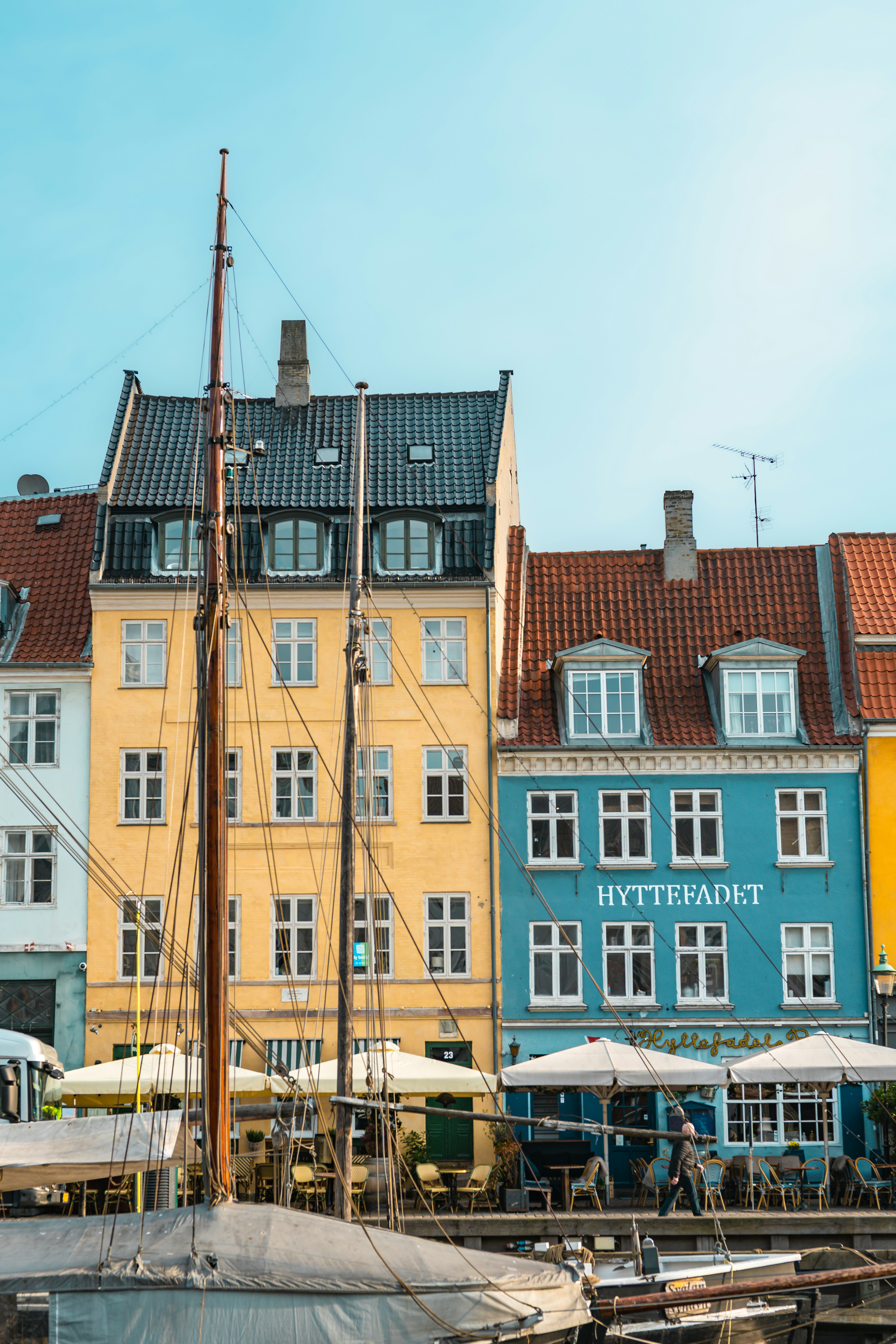 Row of Colorful Riverside Townhouses Framed by Sailing Mast
