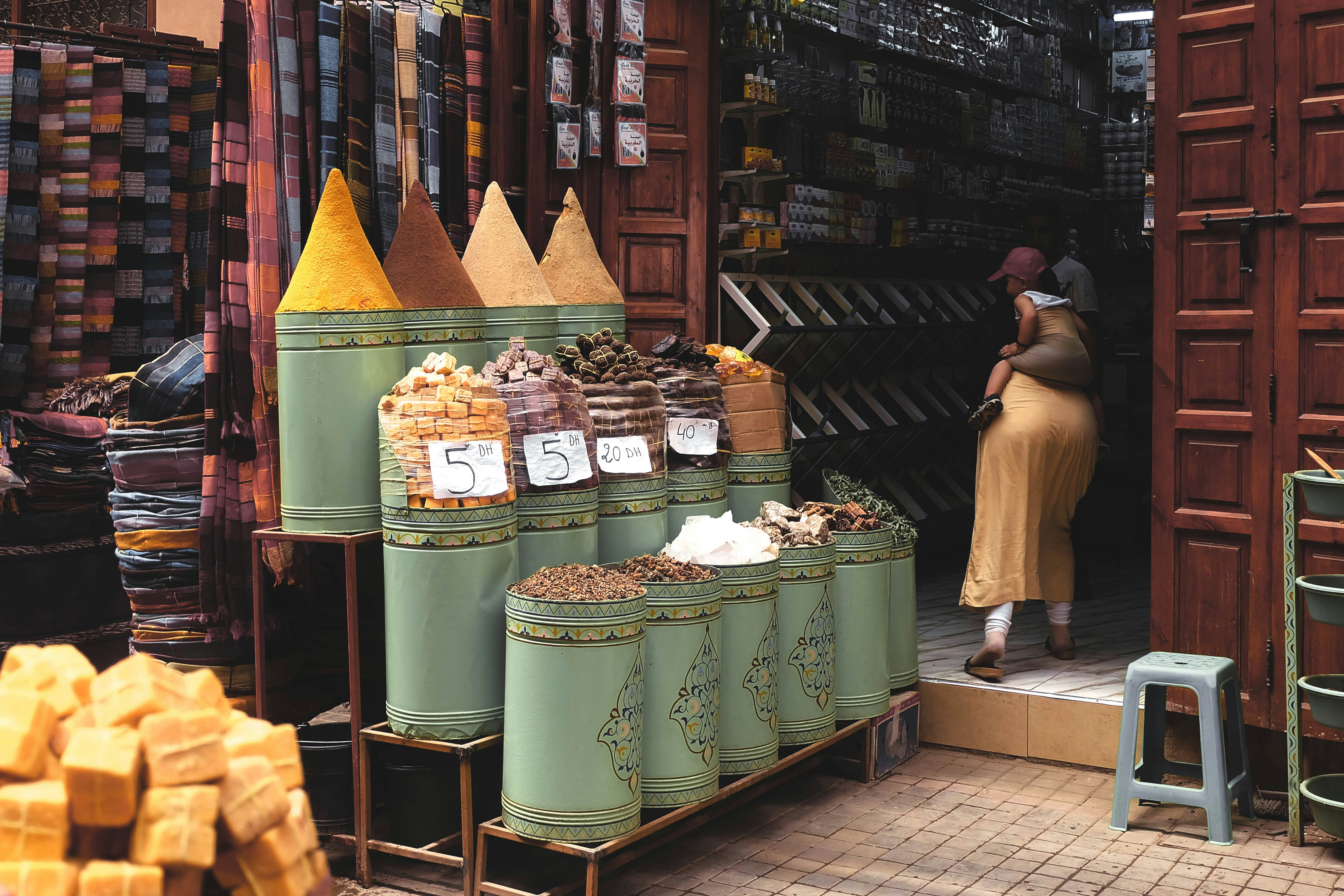Colorful Spices and Shaded Shopper at a Market Stall