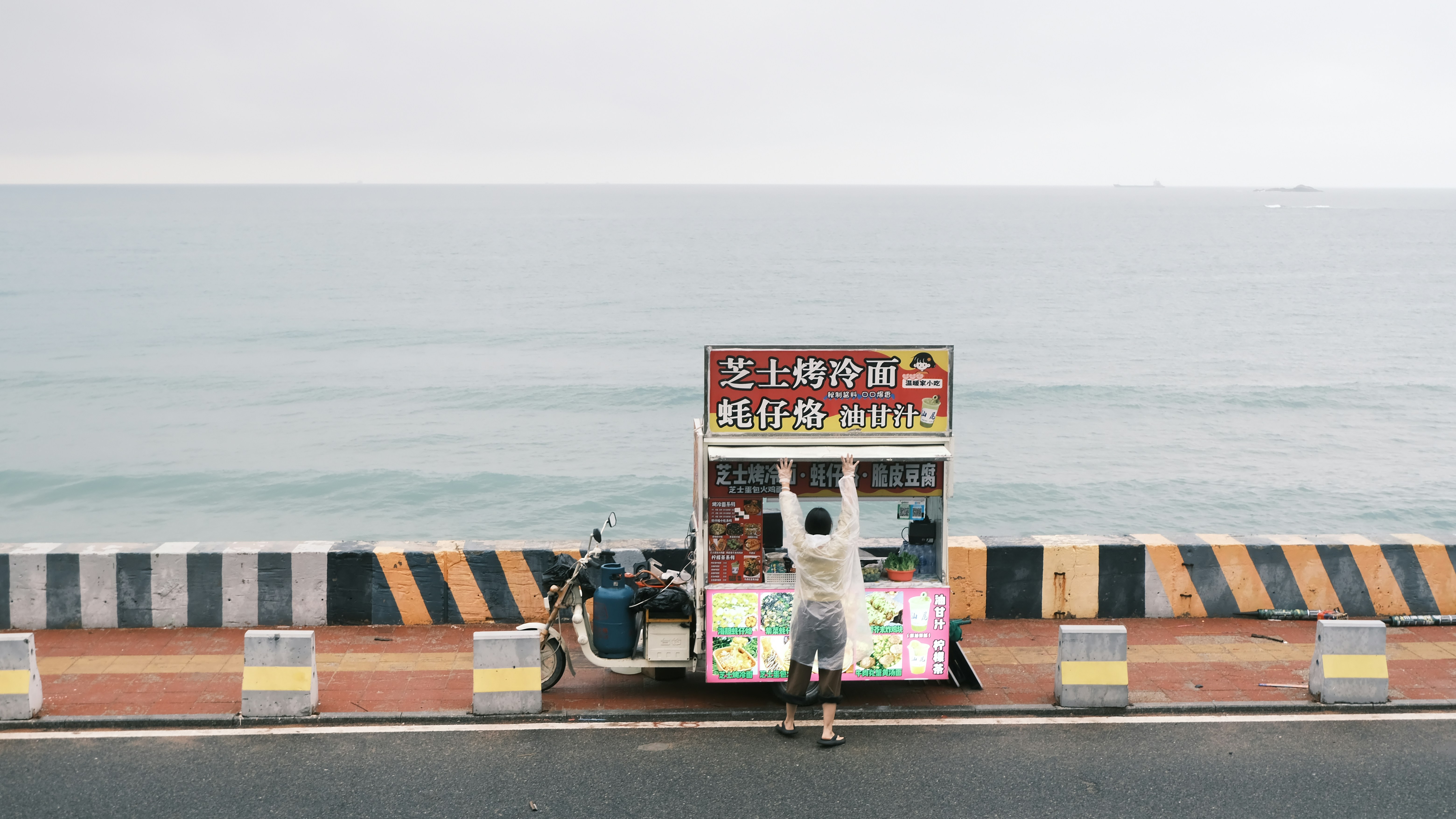 Vendor at the Seaside Snack Stall by a Striped Breakwater