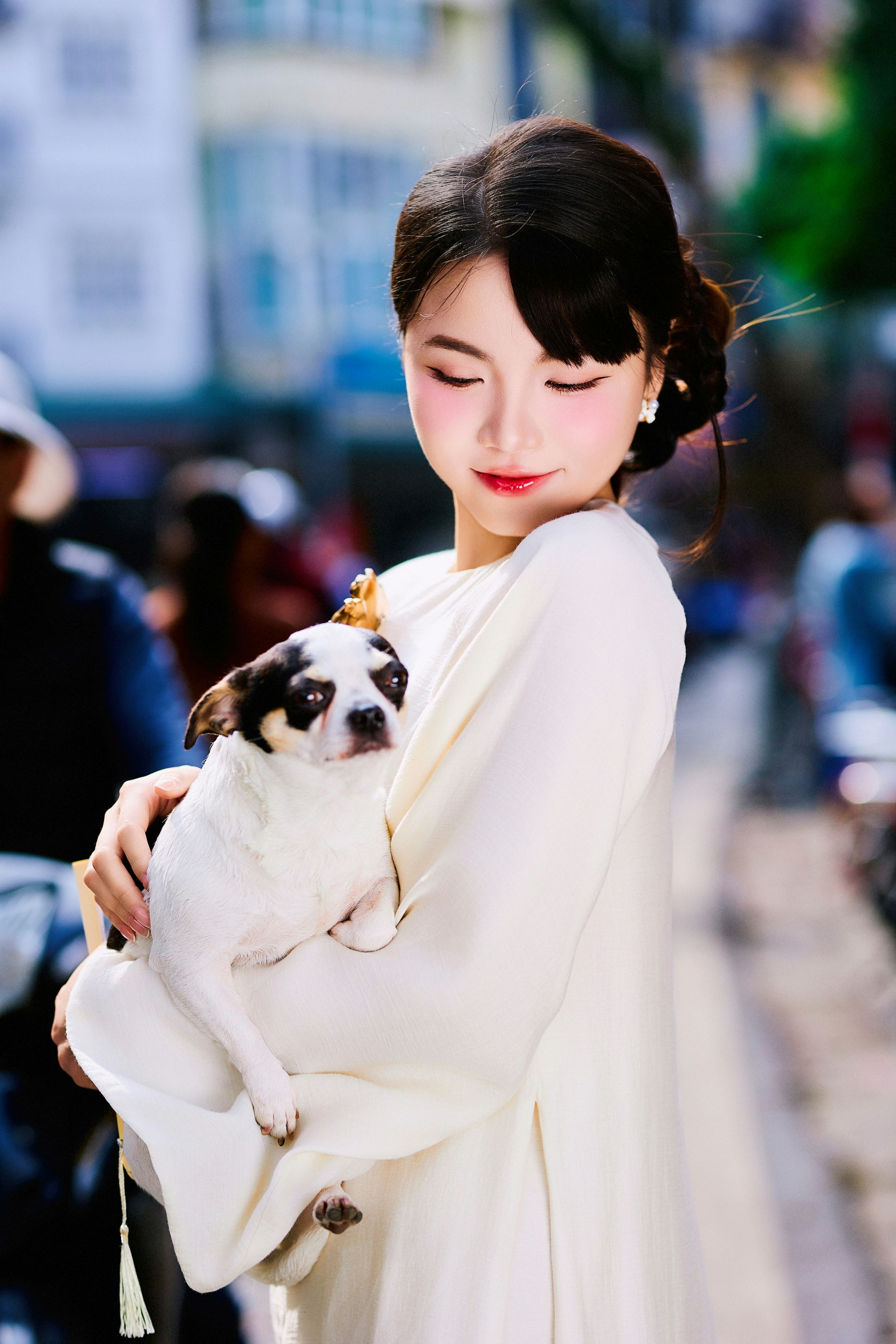 Soft Embrace: A Woman and Her Papillon in a Sunlit Street Portrait