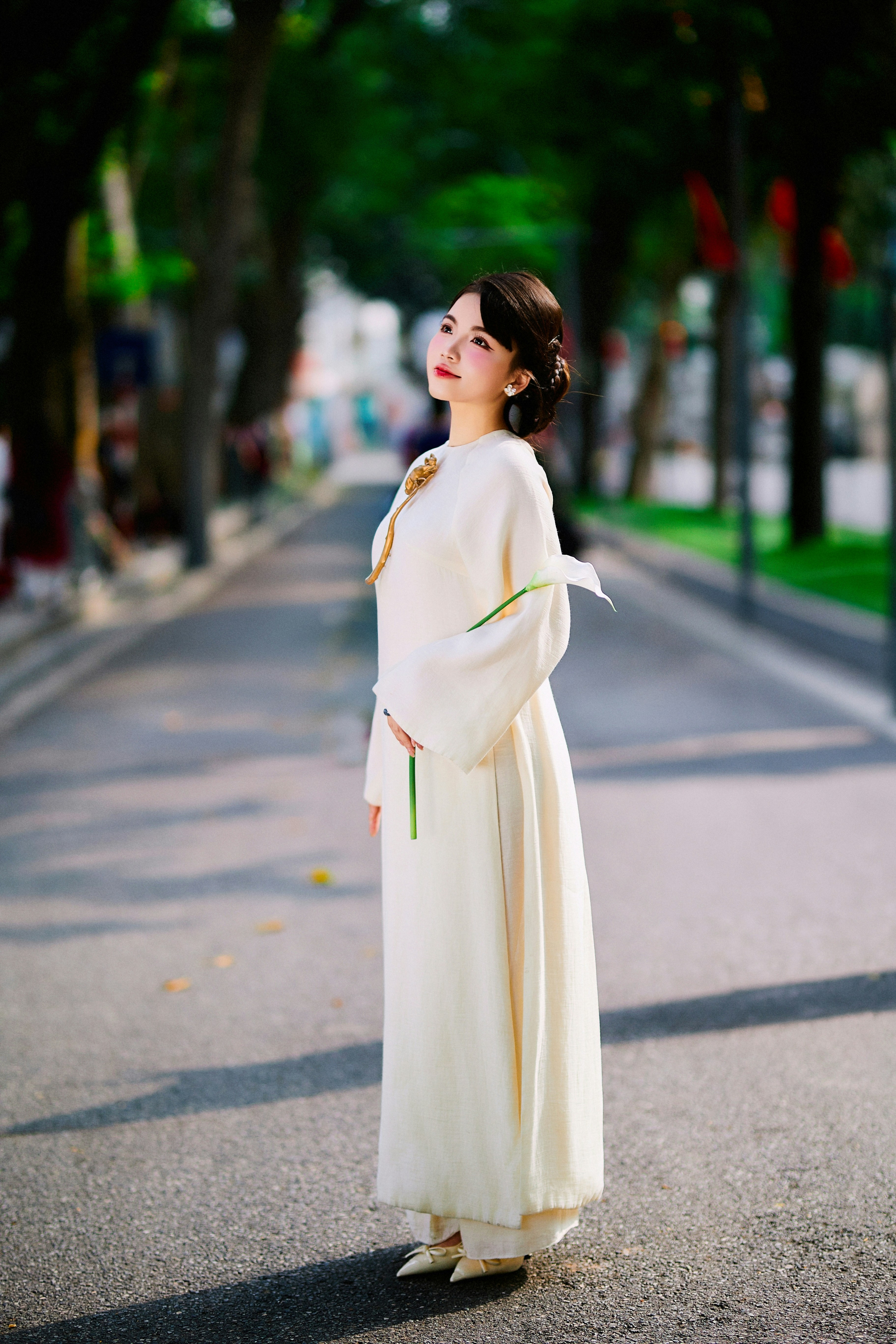 Portrait in White: A Contemplative Gown on a Sunlit City Avenue