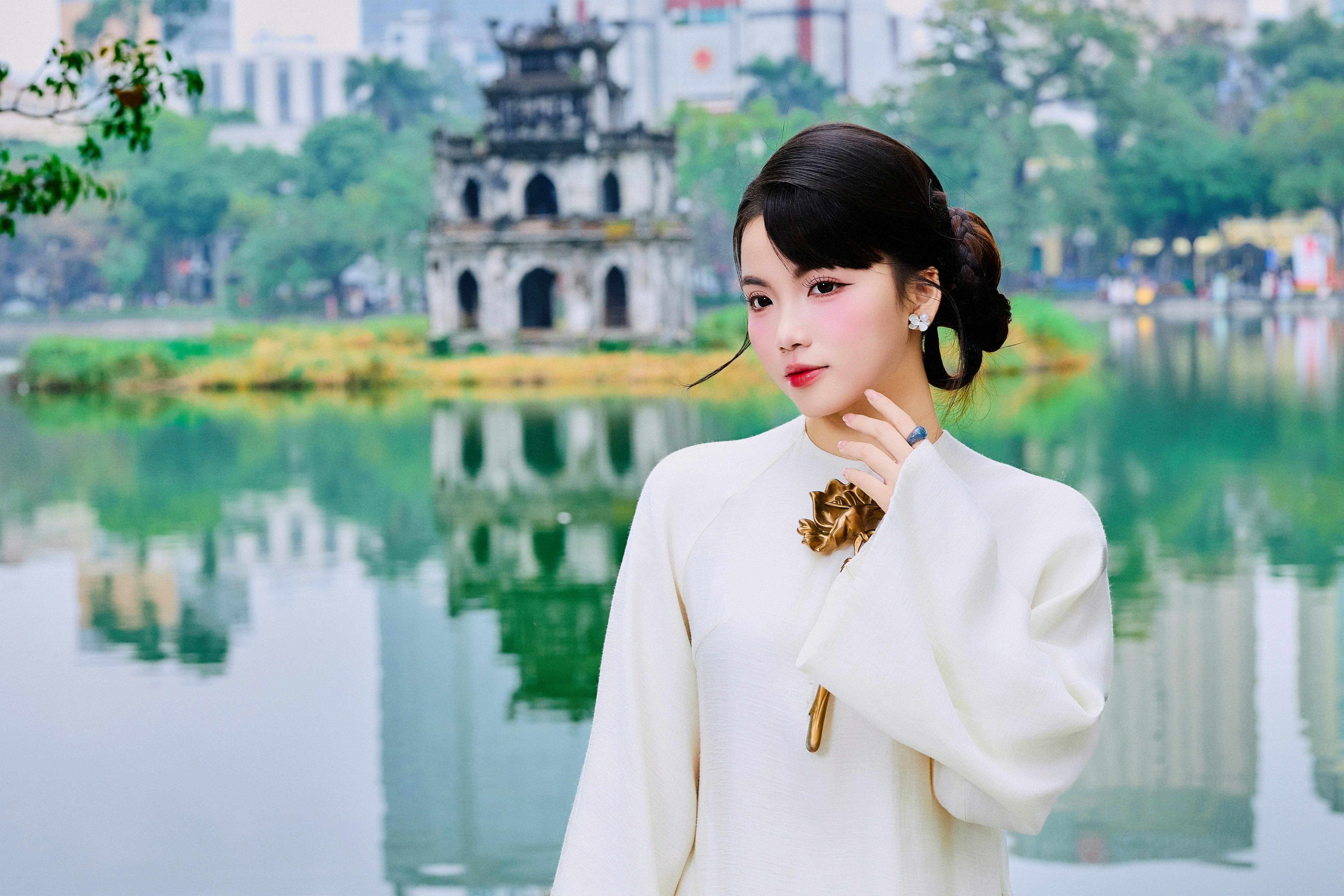 Portrait by the Lakeside: Elegance in White Against a Historic Reflection