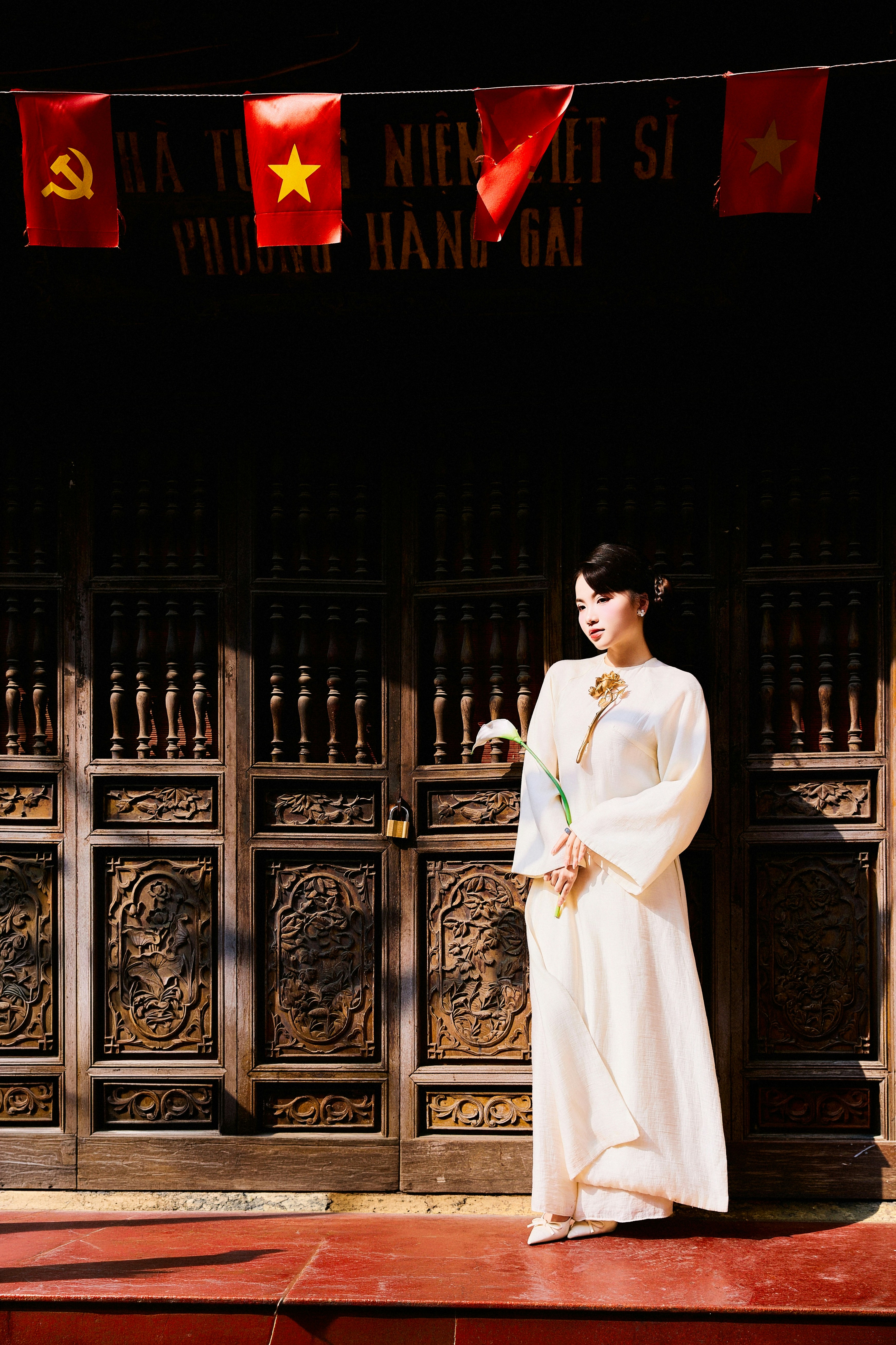 Elegance Beneath Red Banners: A Poised Moment in Traditional attire