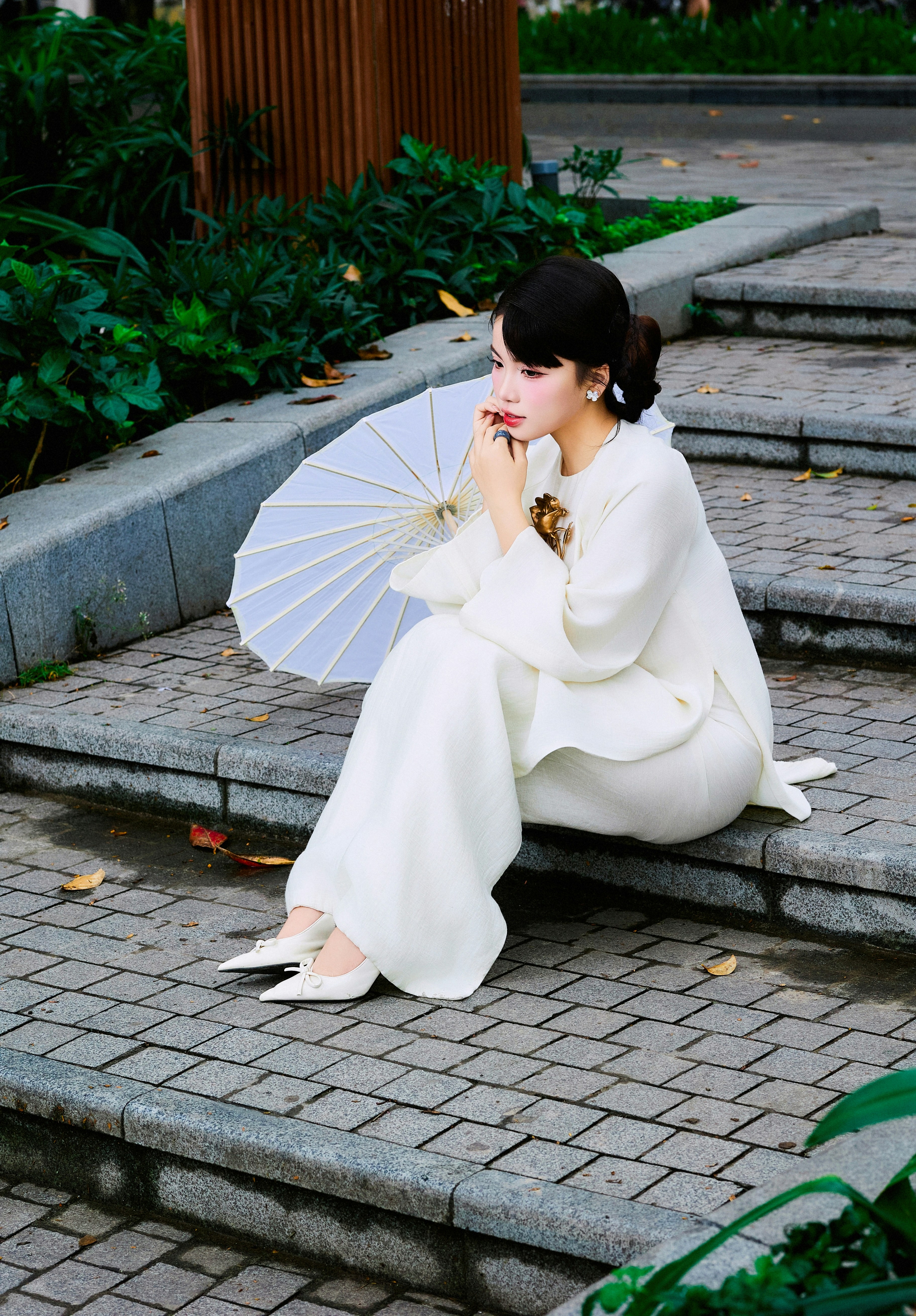 Serene Solitude in White: A Quiet Moment with a Paper Umbrella