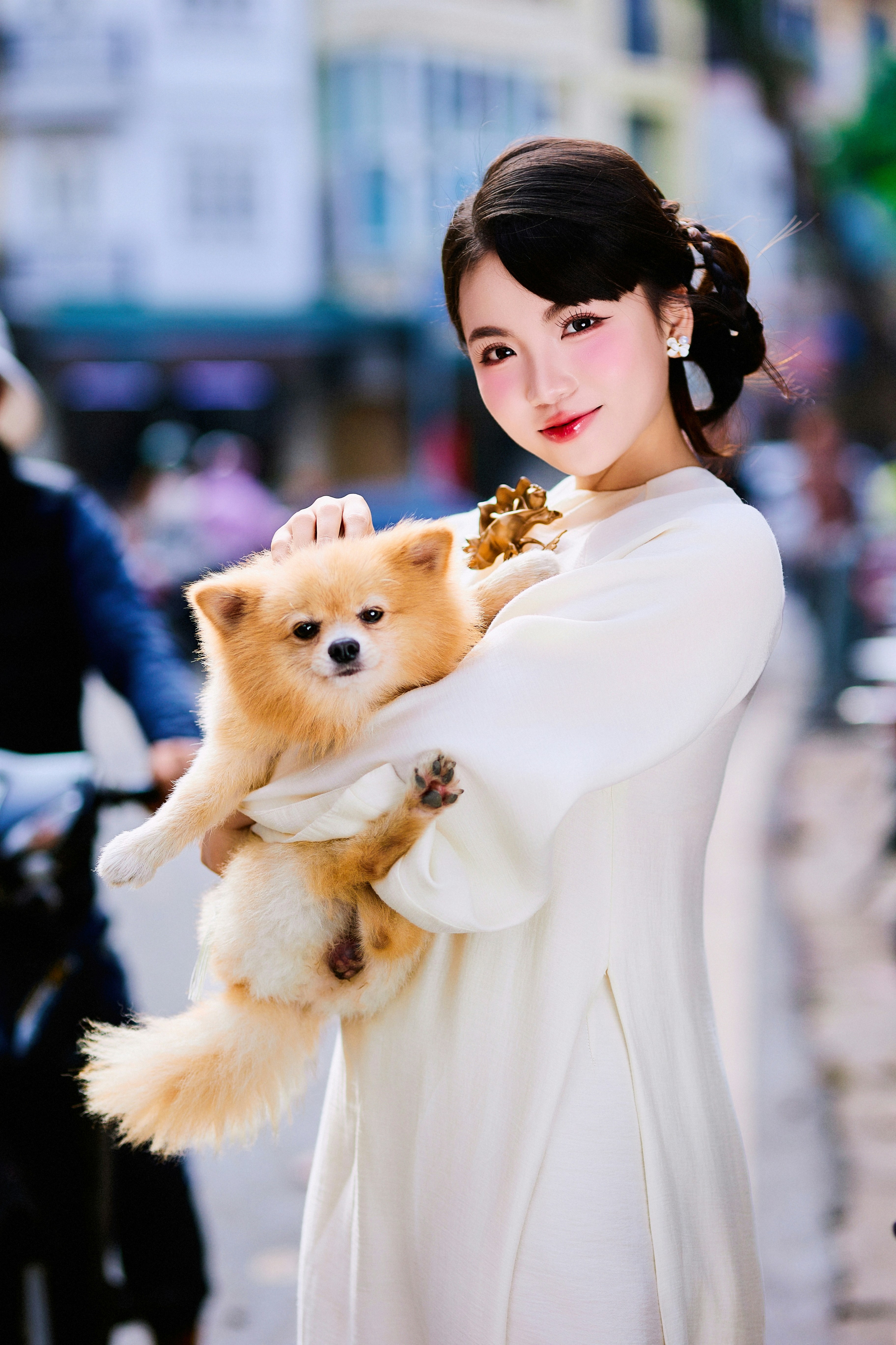 Portrait of Grace: A Woman in White with a Pomeranian in Hand