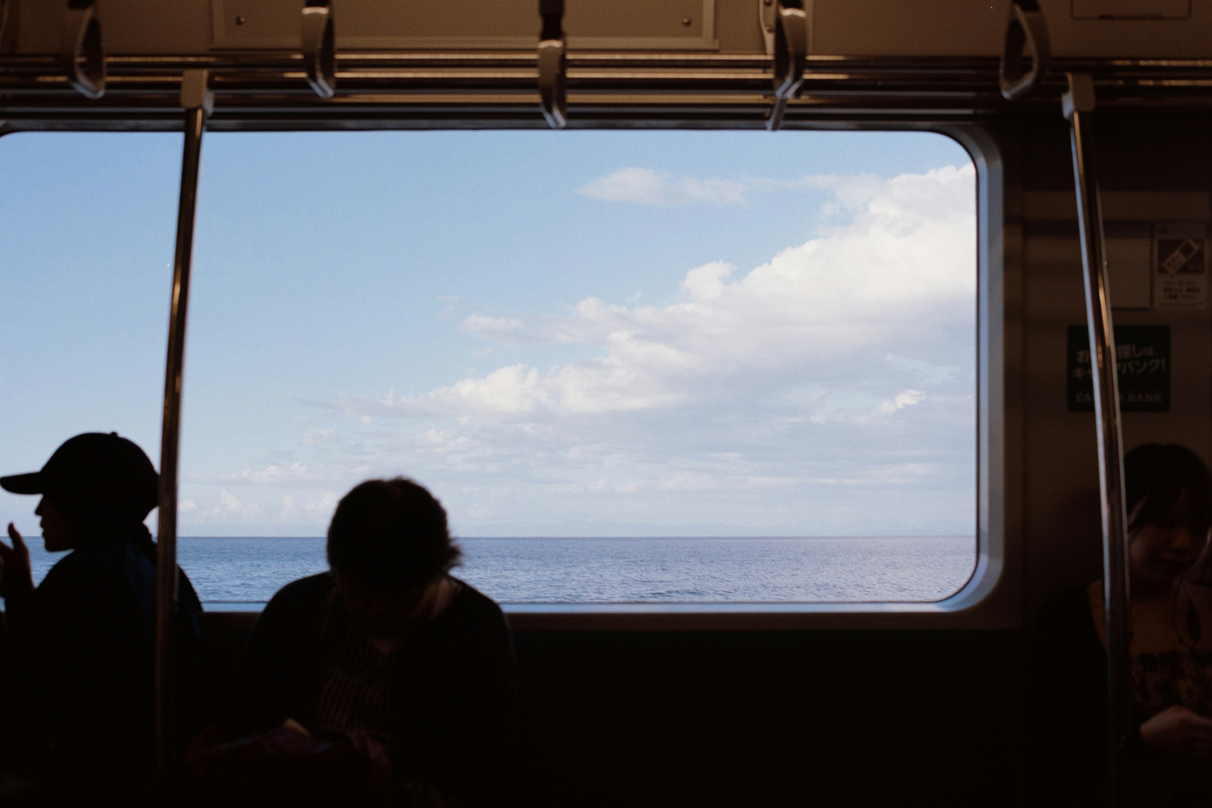 Coastal Window: A Quiet Sea Through a Train Car Frame