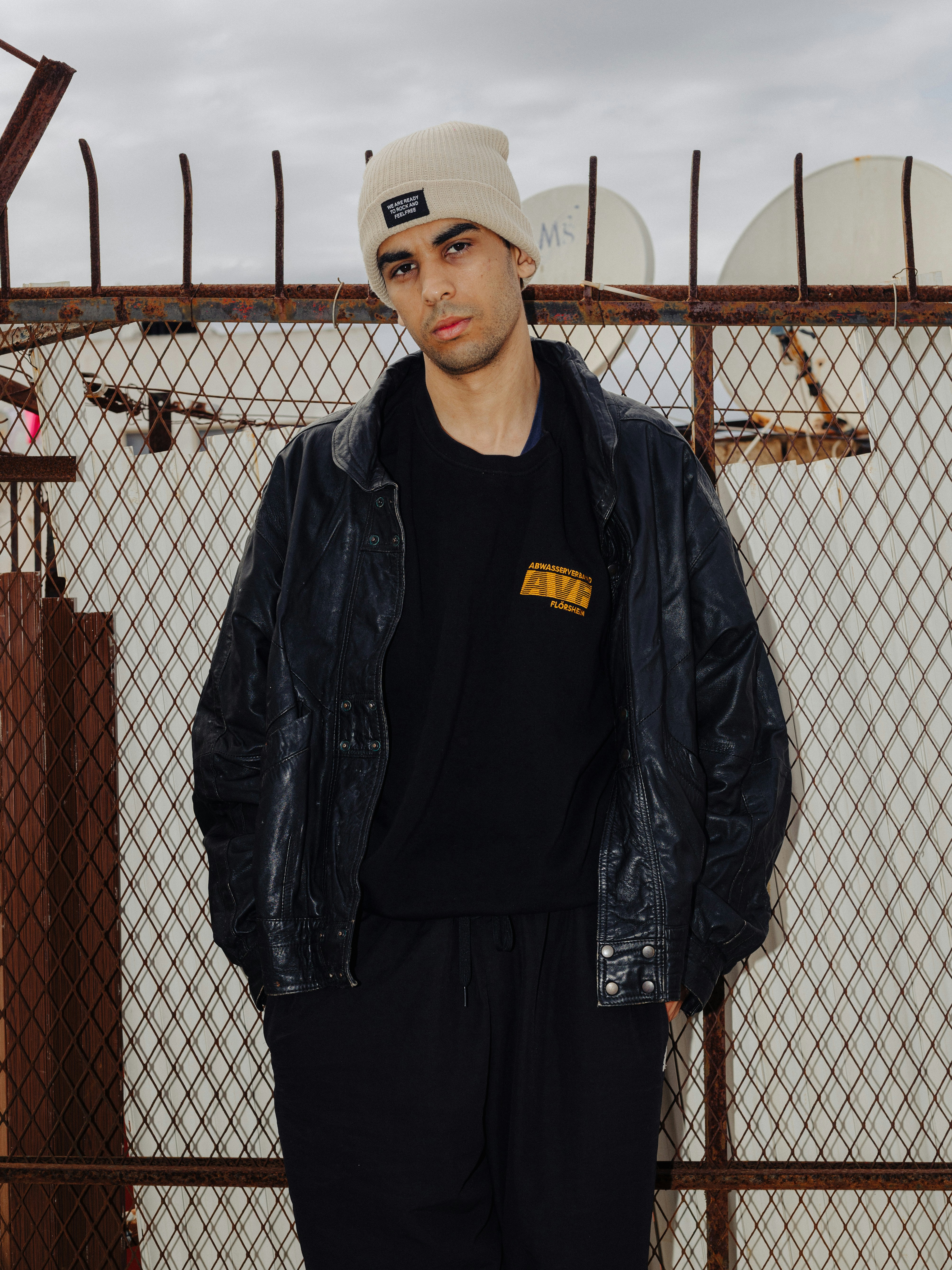 Midnight City Grit: Portrait Against Rusted Fence