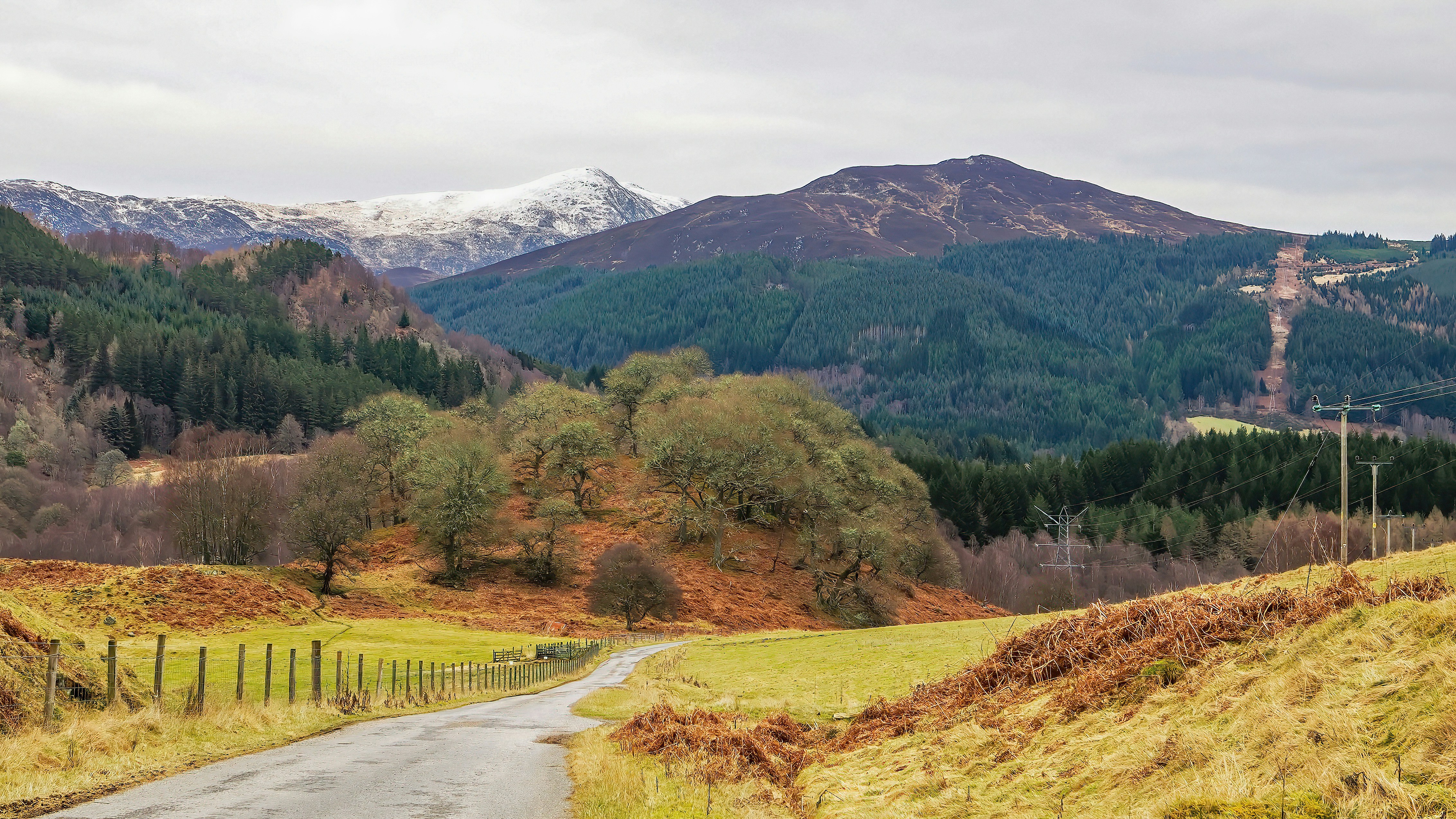 Whispering Valley Road Under Snow-Dusted Peaks
