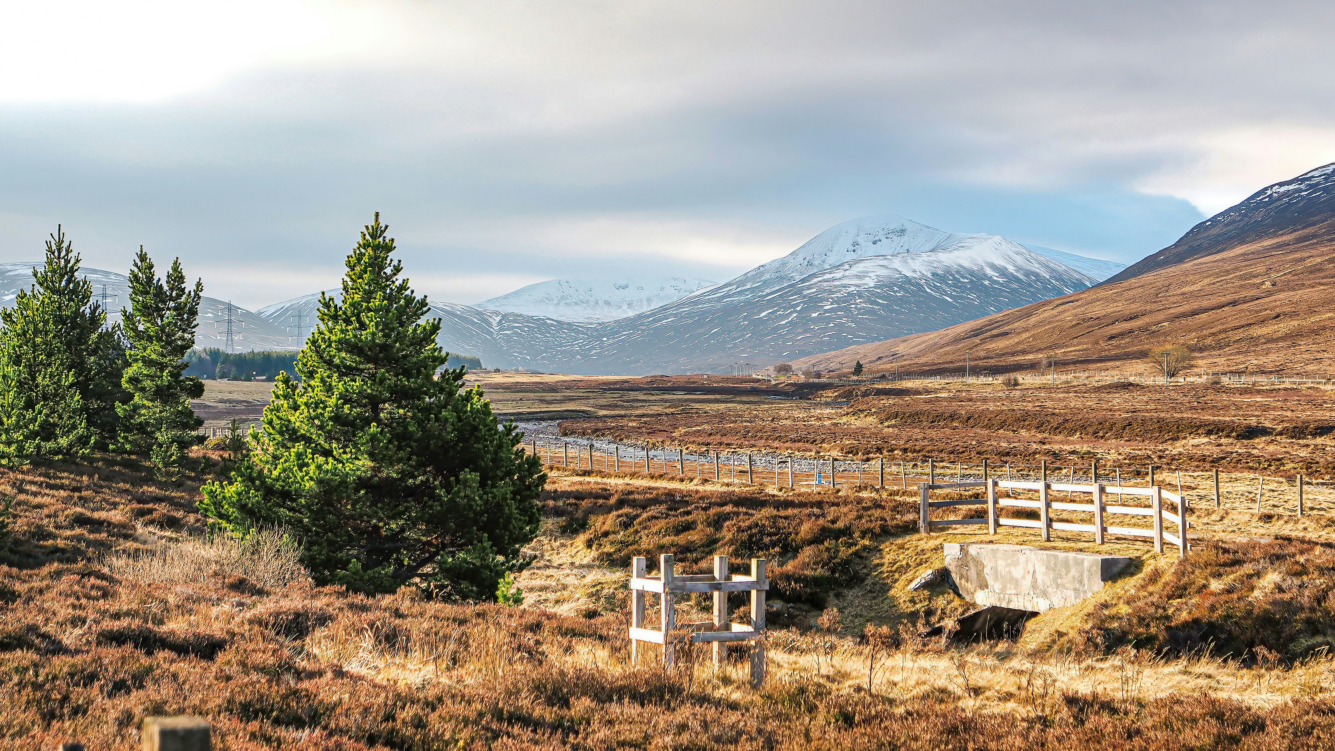 Fence Lines and Snow-Dusted Peaks: A Quiet Highland Crossing