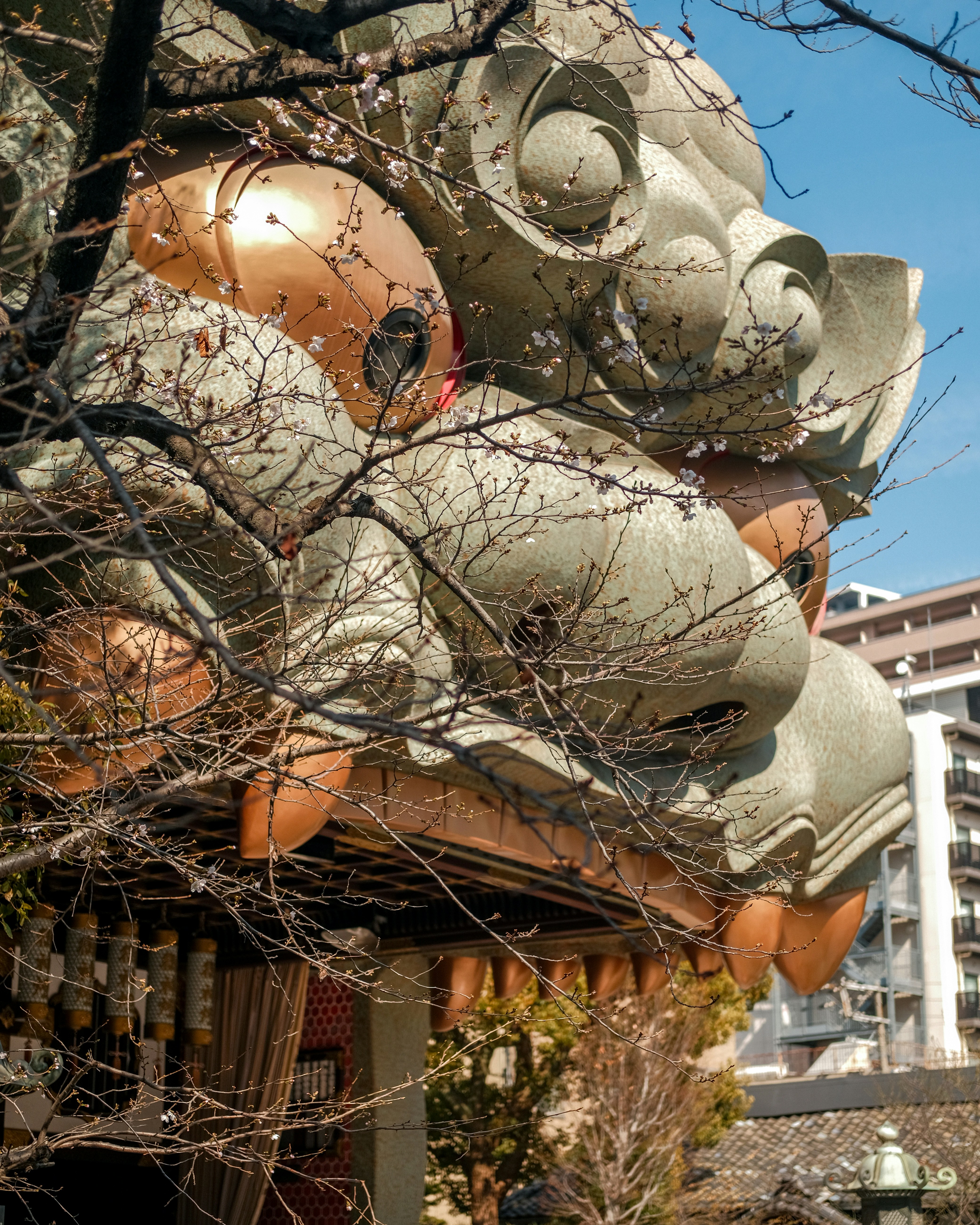 Stone Dragon Heads Loom Over Blossoms in Urban Temple