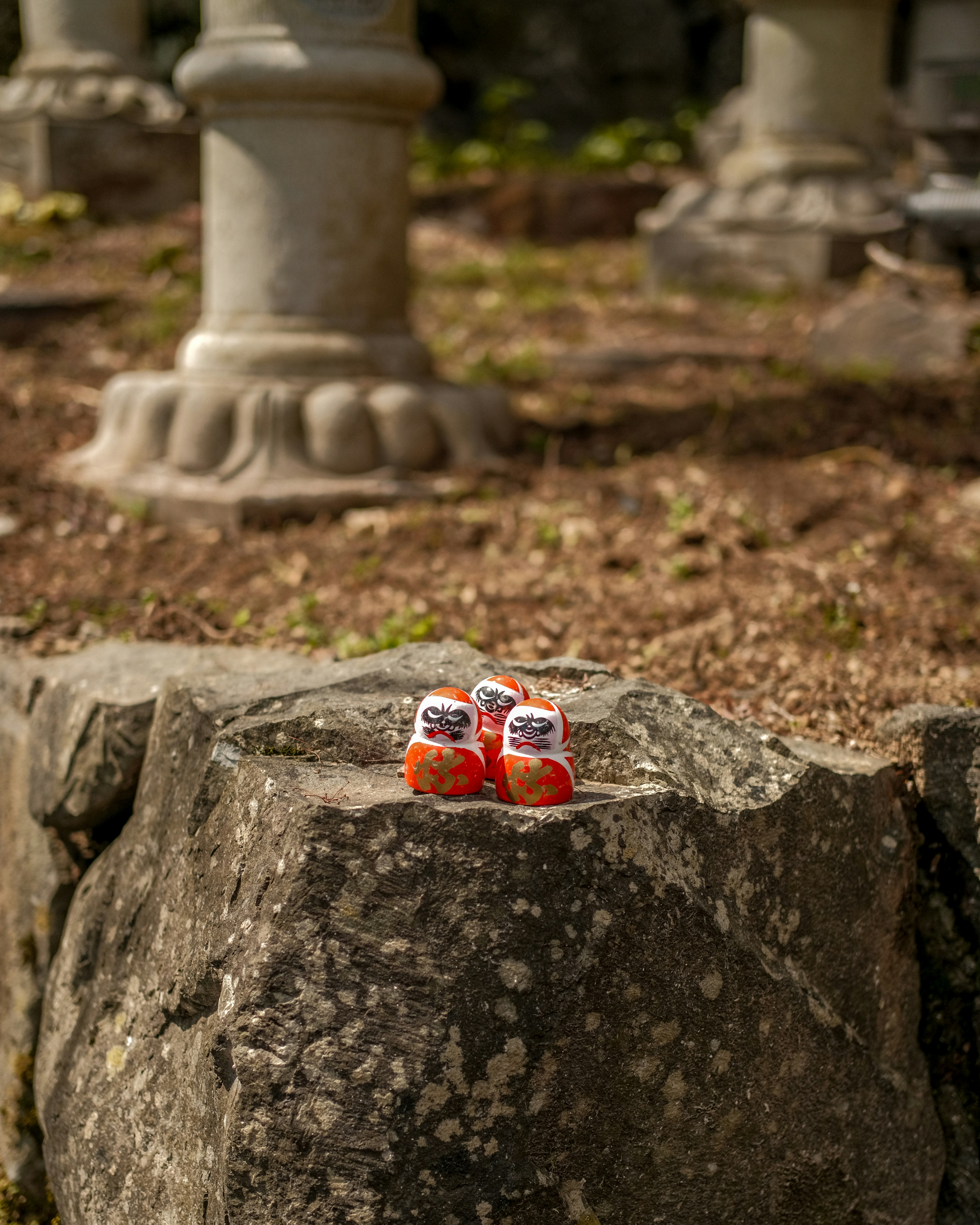 Three Daruma on Weathered Rock in a Quiet Shrine Garden