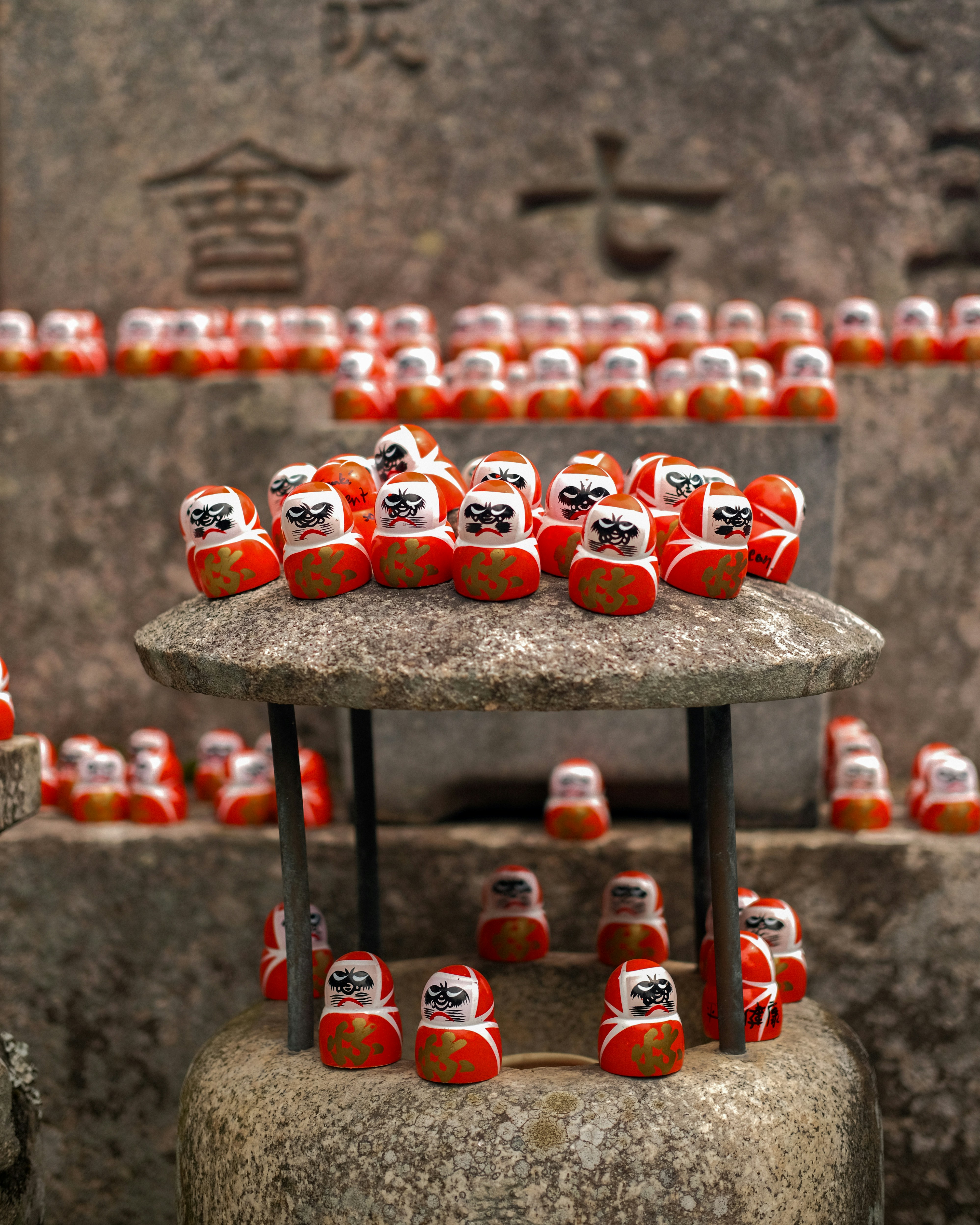 Kitsune of the Lantern Table: Rows of Daruma Dolls on Stone Stages