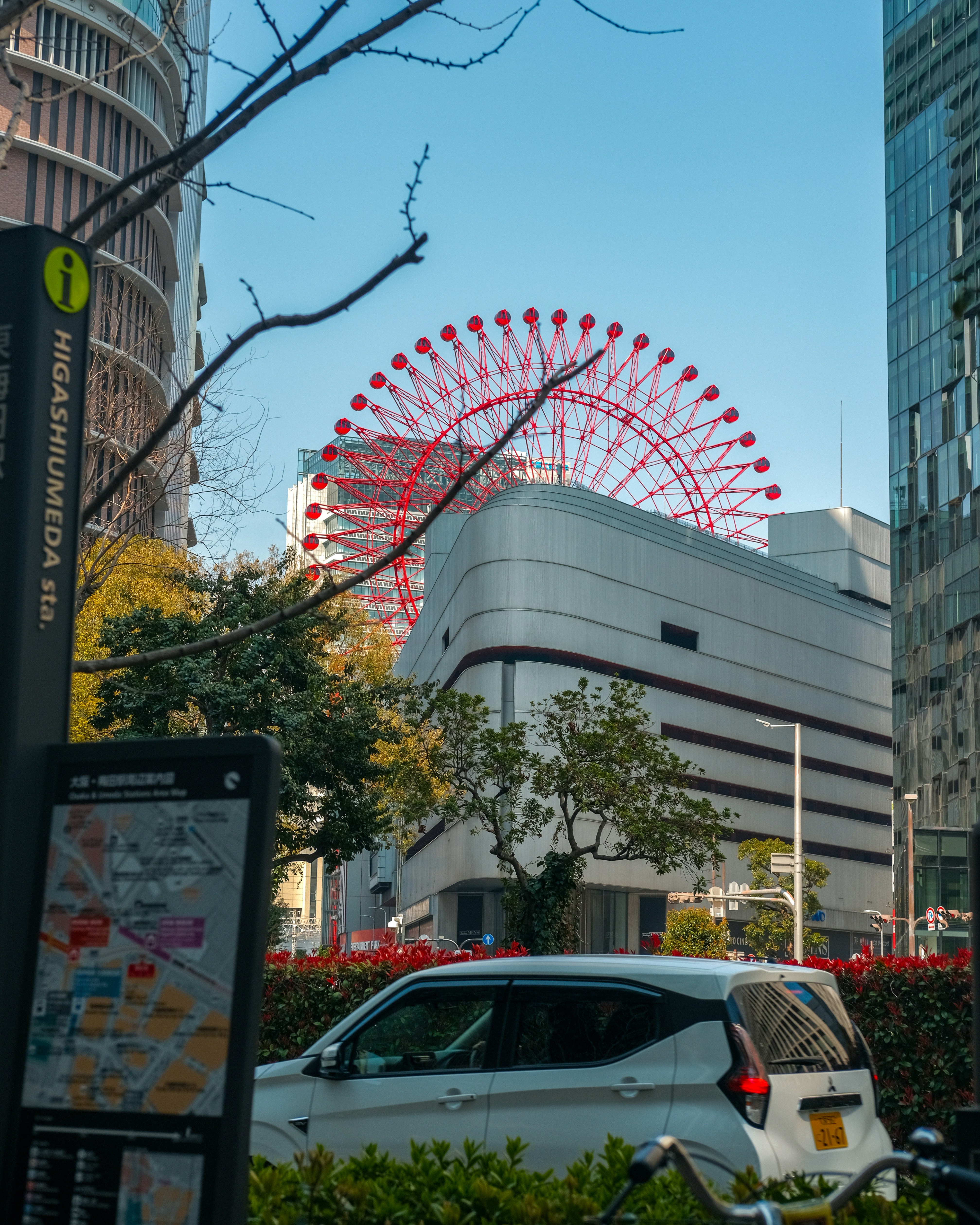 Urban Circle: A Red Ferris Wheel Framing a Quiet Street