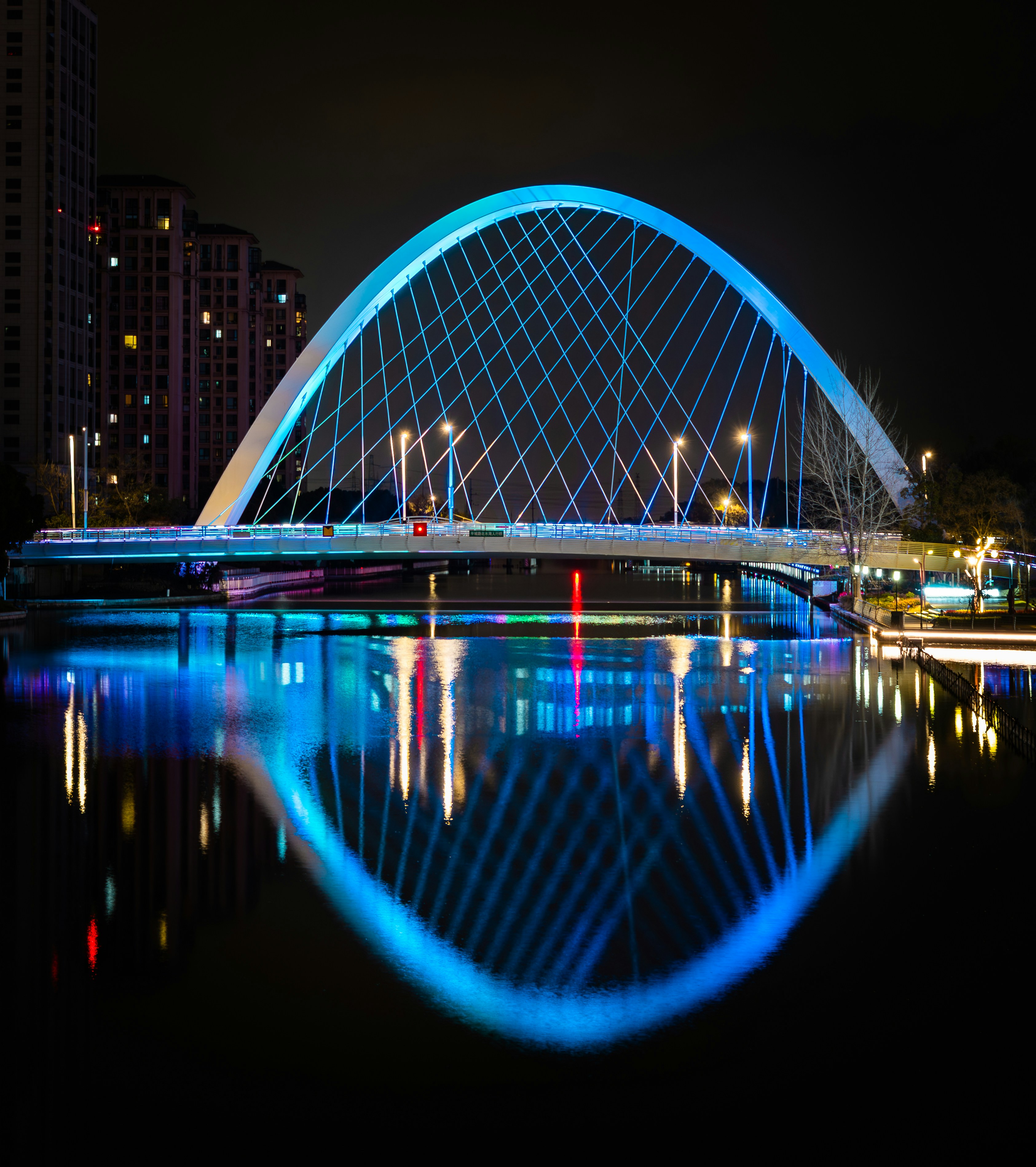 Blue Arc over the River: Night selfie of a luminous cable-stayed bridge